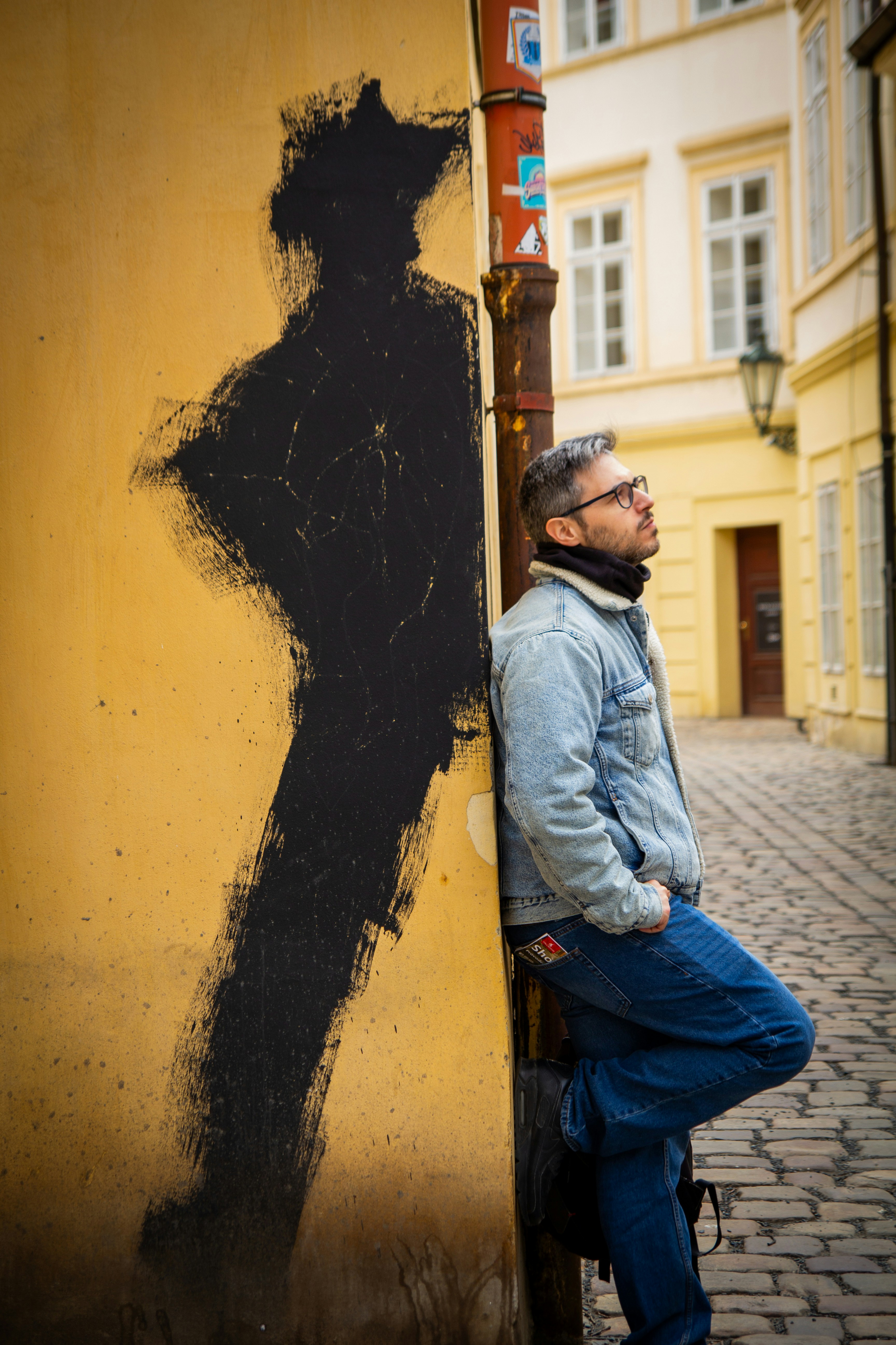 Street Portrait: A Quiet Repose Beside a Painted Wall