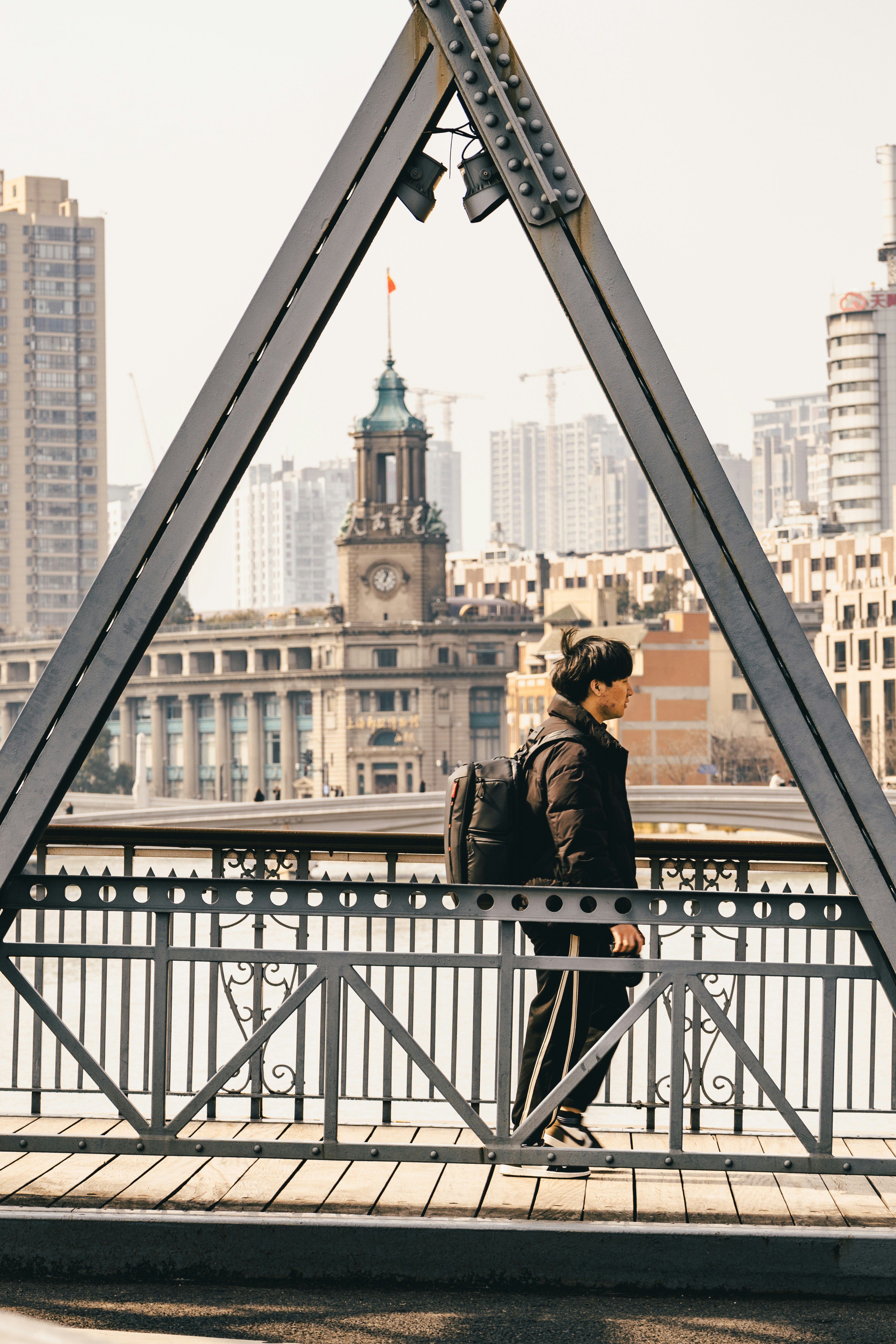 Crossroads on a Steel Arch: A Lone Pedestrian Against a City Horizon