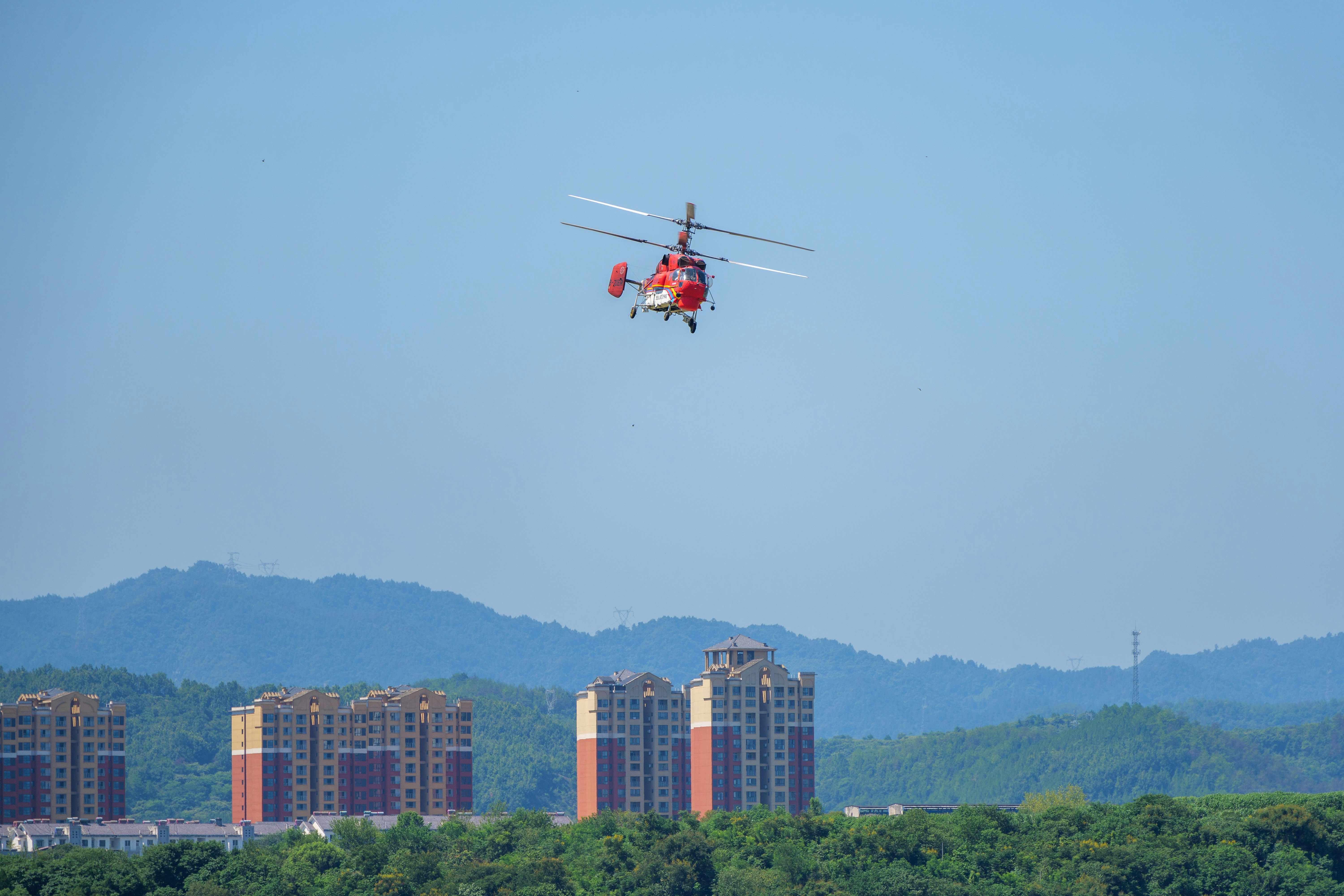 Red Rescue Helicopter Over Suburban Skyline