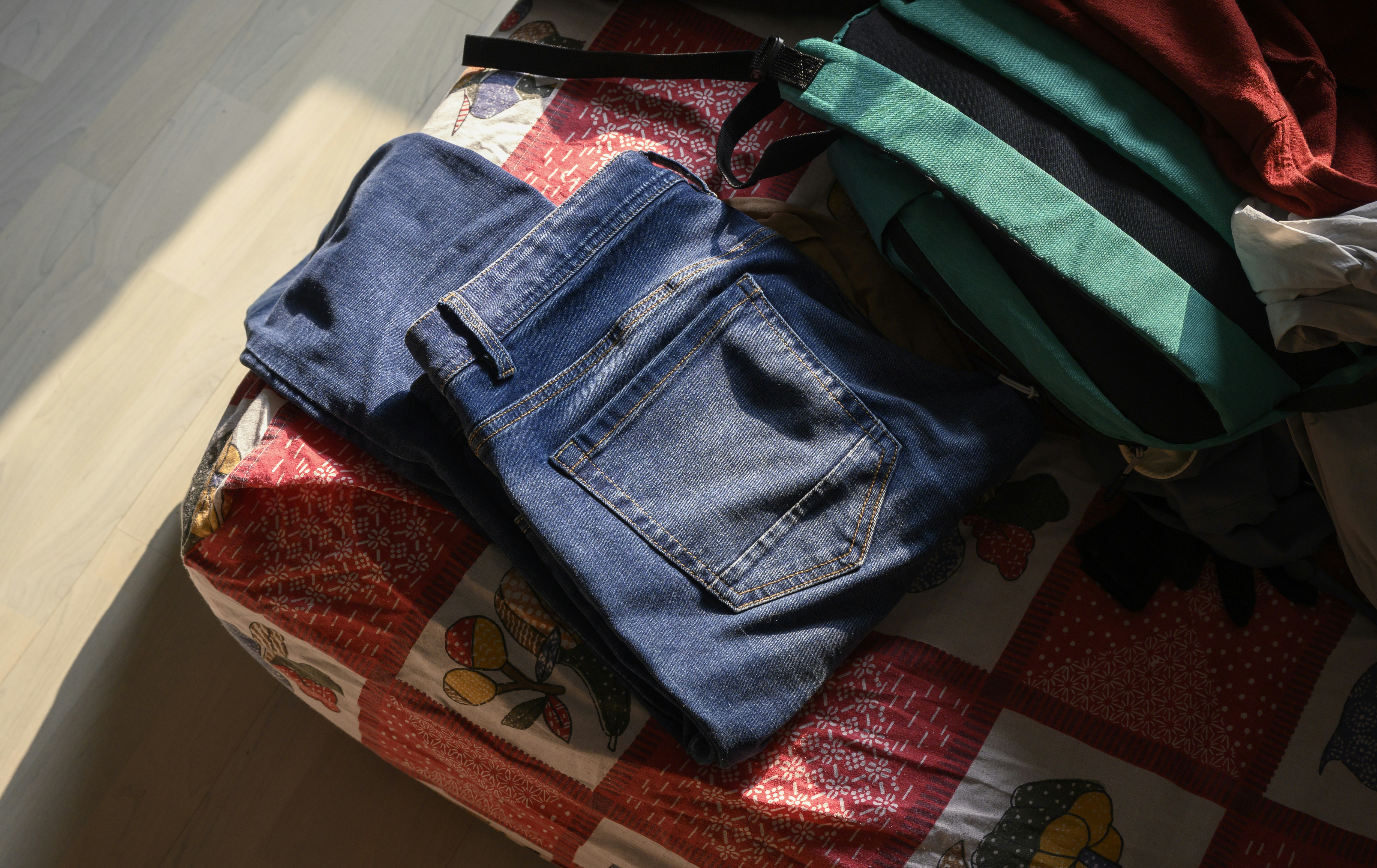 Folded Jeans atop a Colorful Quilt: Casual Wardrobe on Display