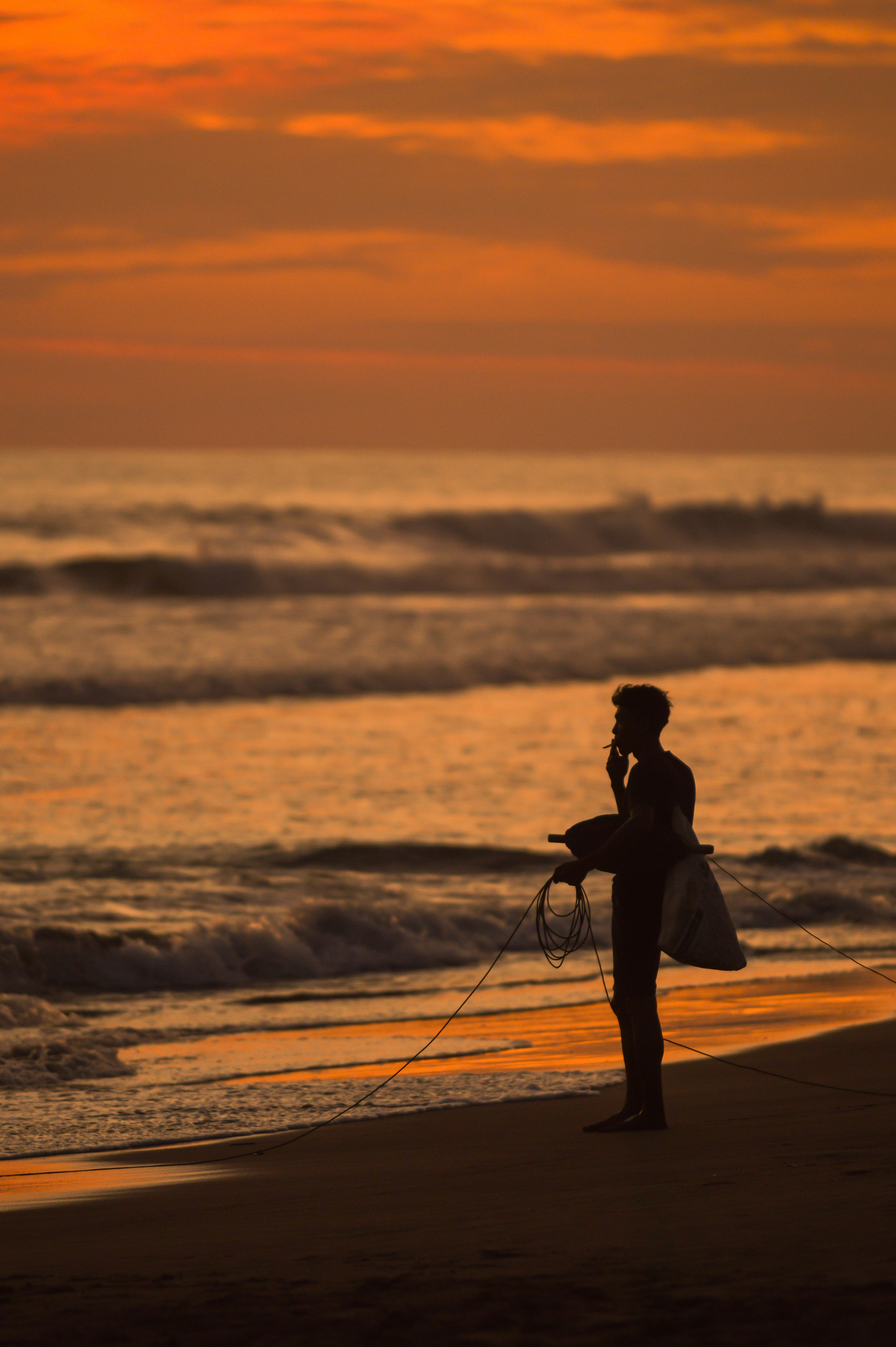 Surfline Silhouette: A Lone Surfer Pauses at Sunset