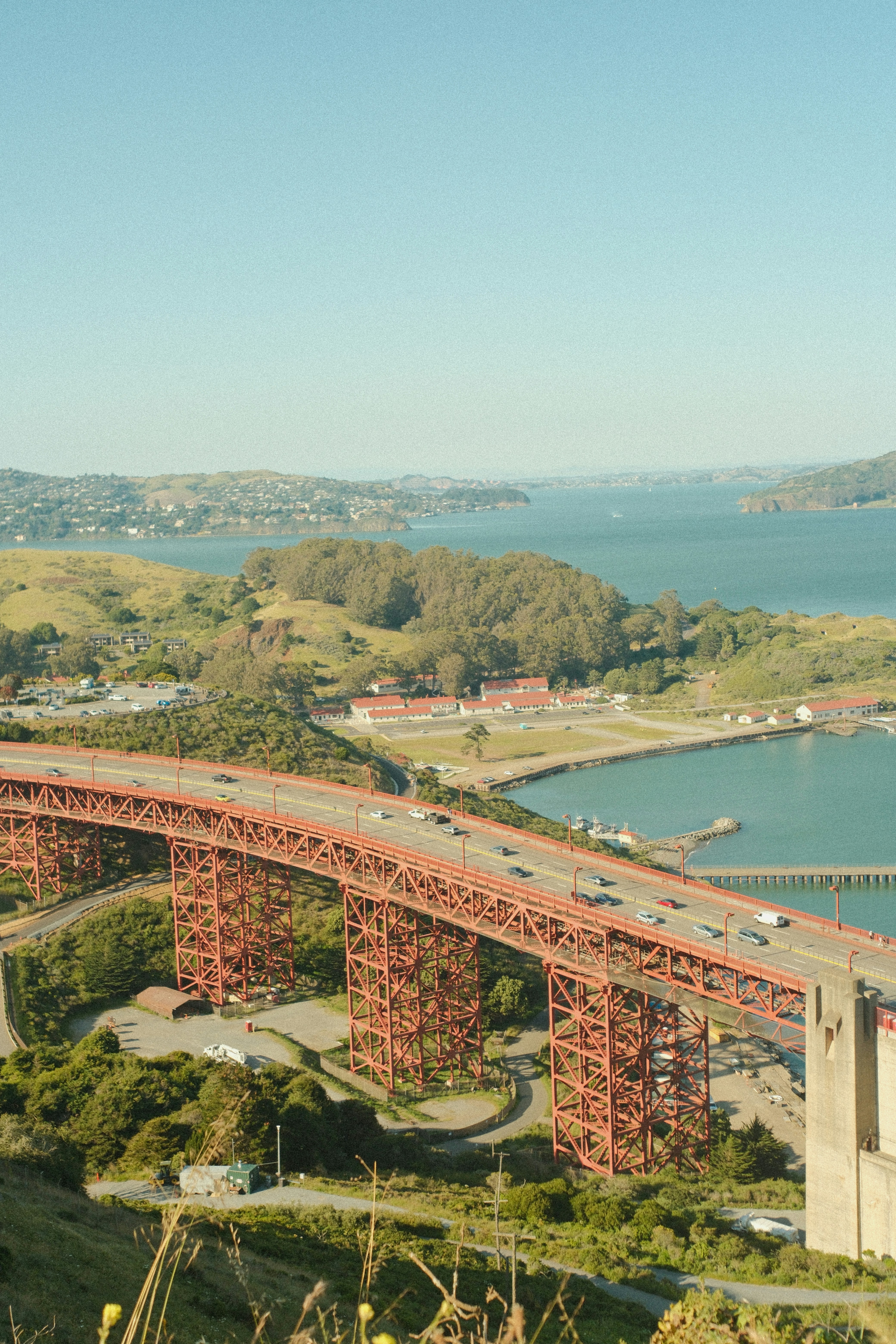 Red Iron Ribbon Over Water: A Coastal Bridge Arc