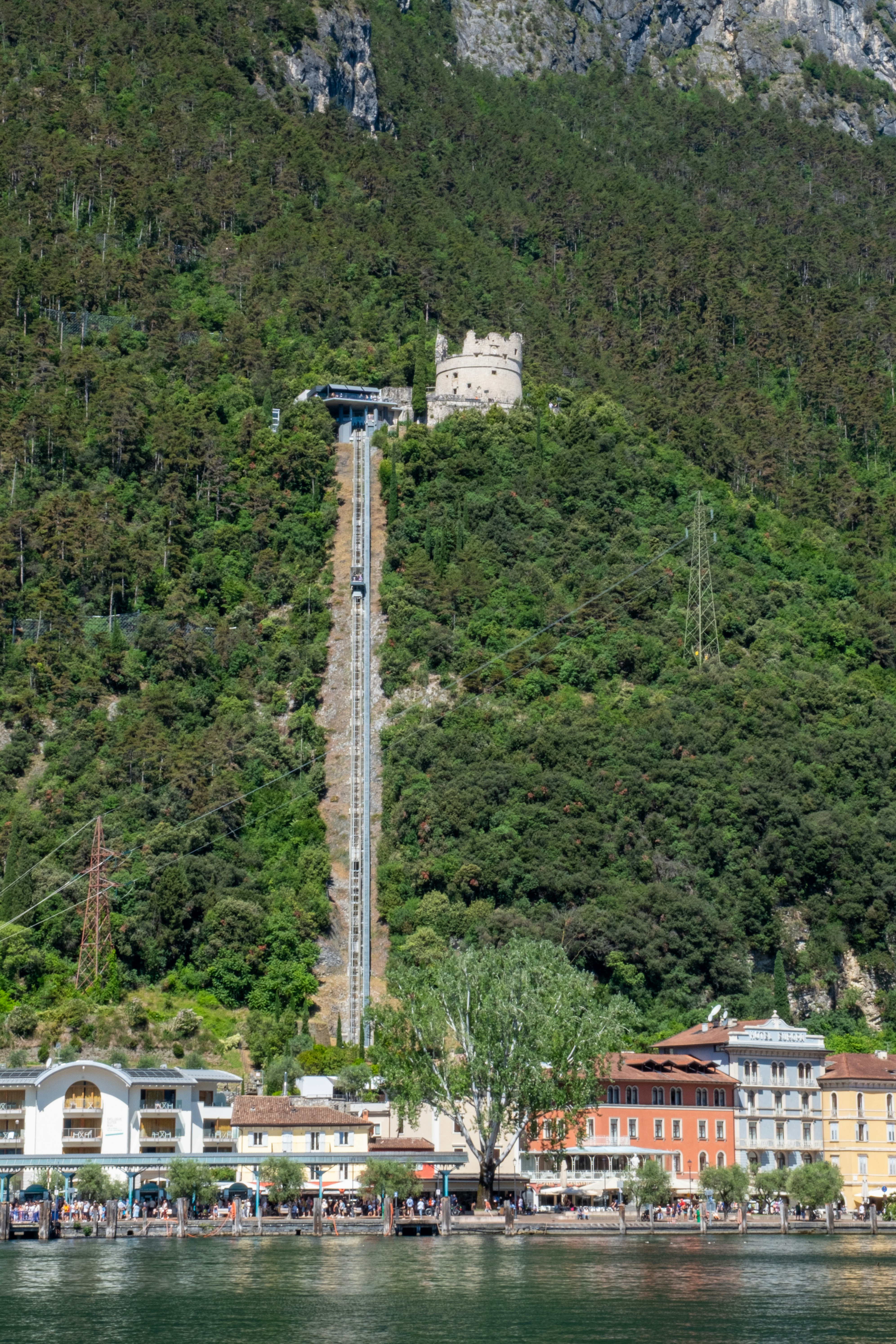 Cascade Lift: A hillside funicular reaching a solitary tower above a lakeside town