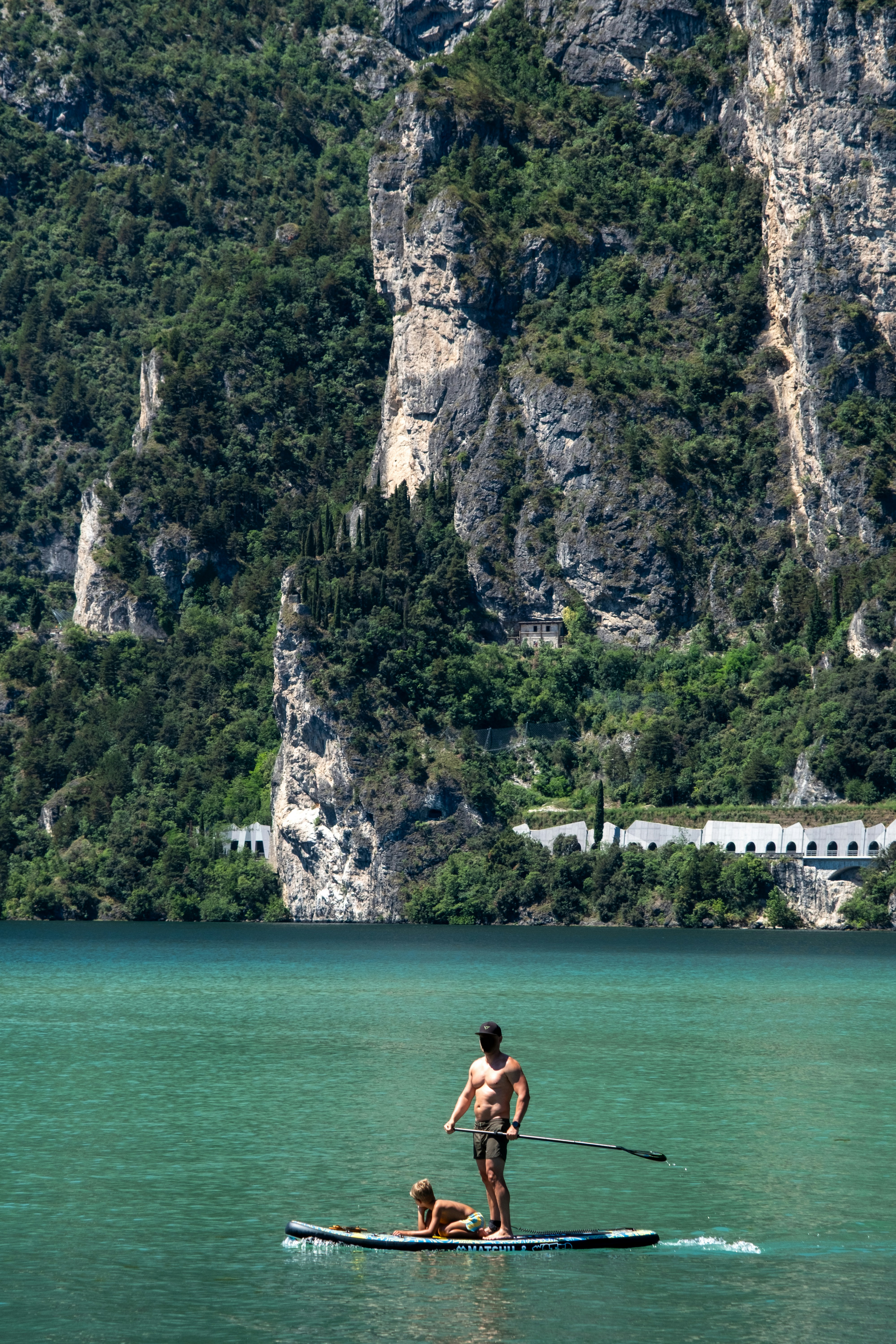Stand-Up Duo on Turquoise Mirror: A Man and Child on Quiet Lake
