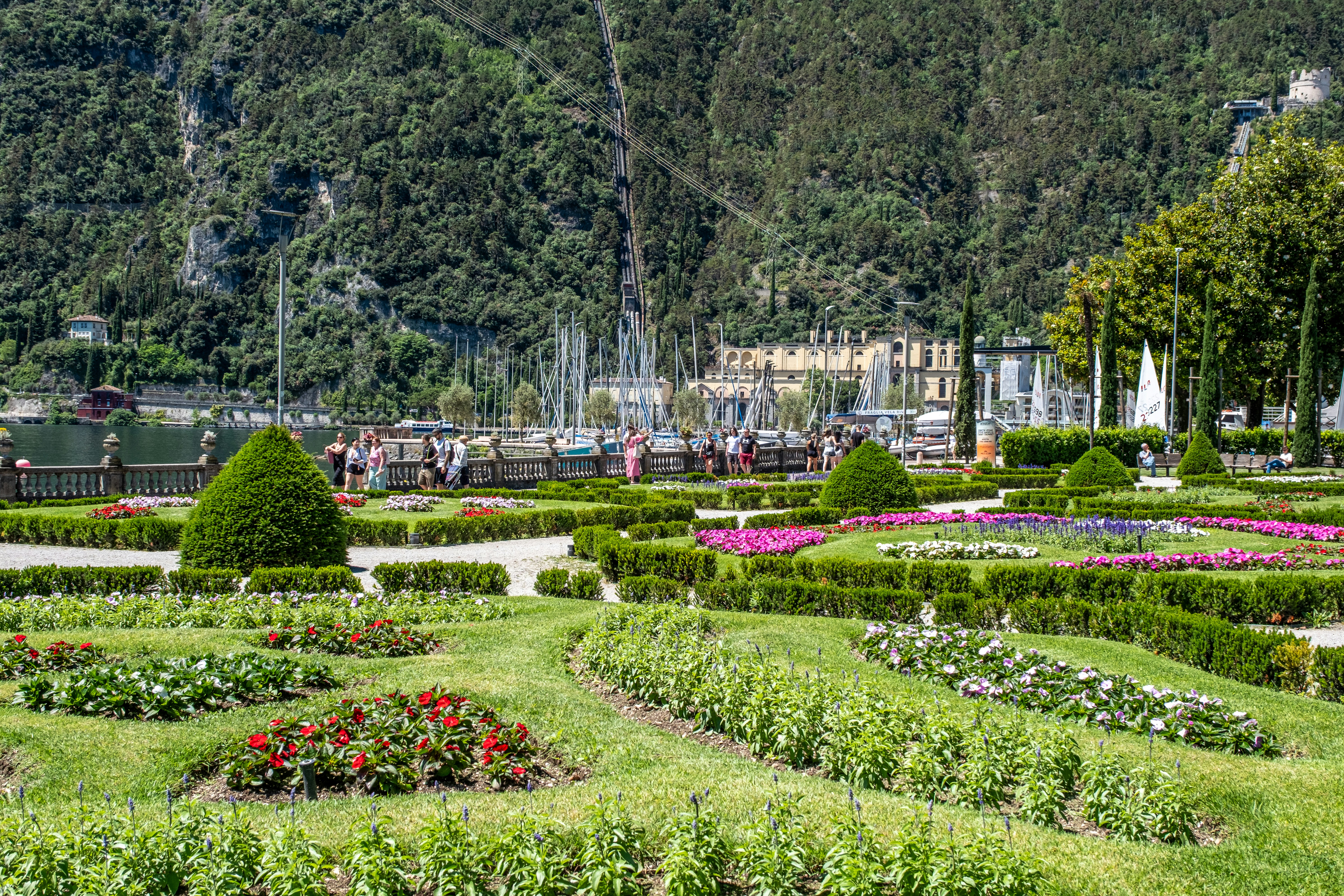 The gardens next to the Fraglia Vela Riva sailing club in Riva del Garda are called Giardini all'Italiana di Punta Lido.These manicured Italian-style gardens are situated at the edge of the lake, providing direct access to the water's edge, with scenic pedestrian paths, and panoramic views of the water and surrounding mountains.