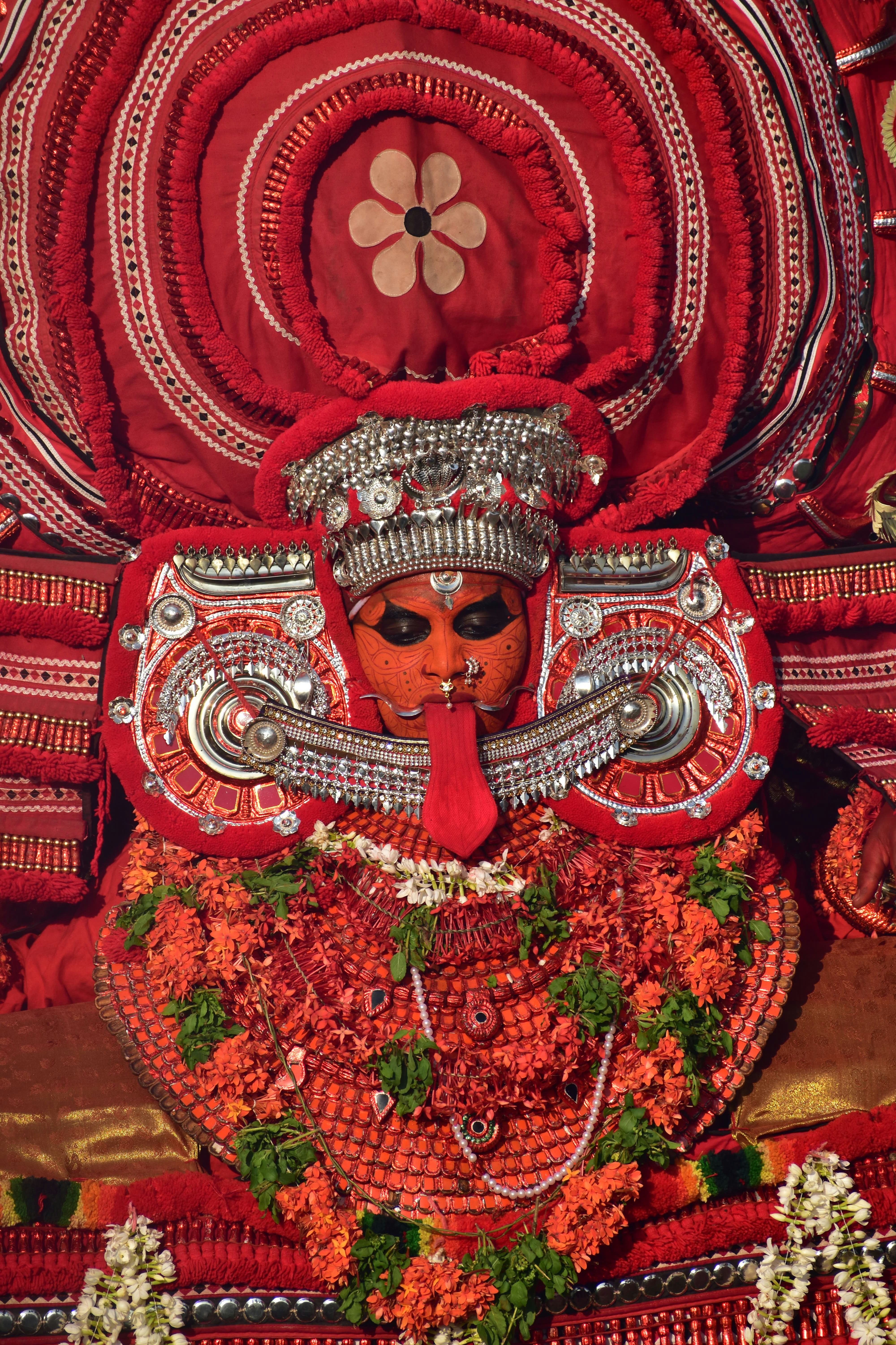 Royal Red: A Ceremonial Mask Adorned in Fire and Floral Ornaments