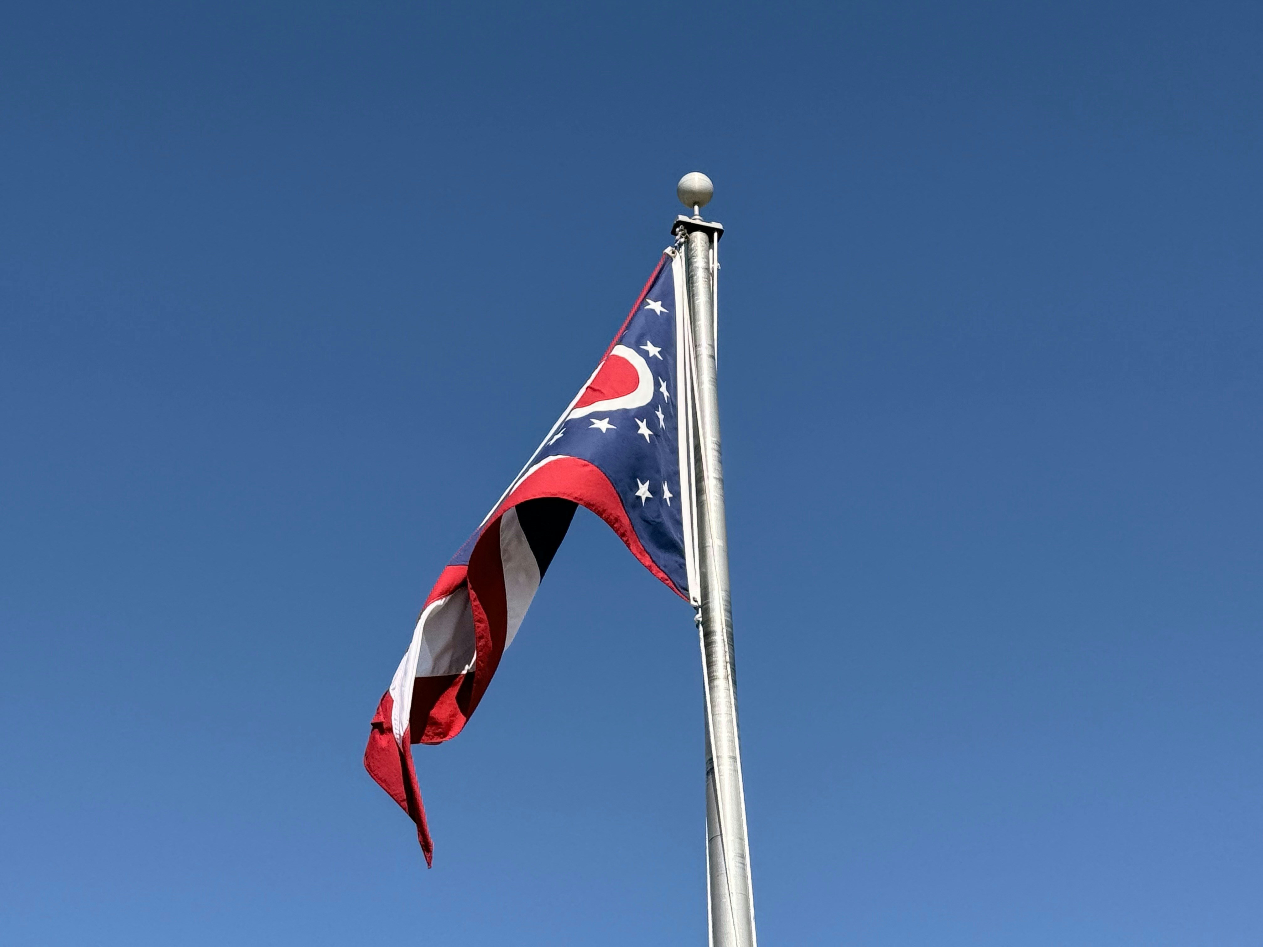 Windward Emblem: A Flag Ripples Against a Clear Sky
