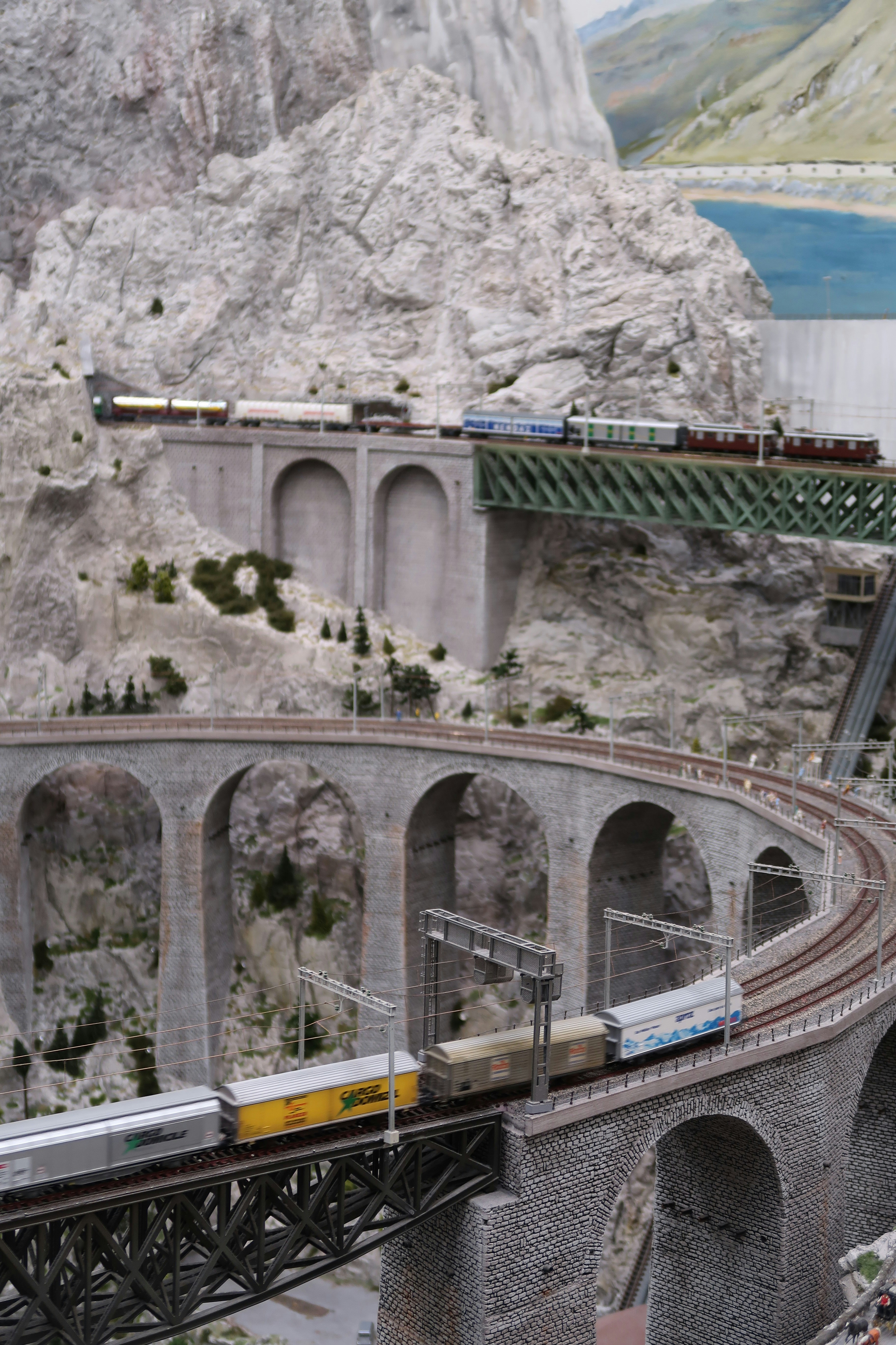 Looming Viaduct Journey: Trains Weave Through a Mountain Pass