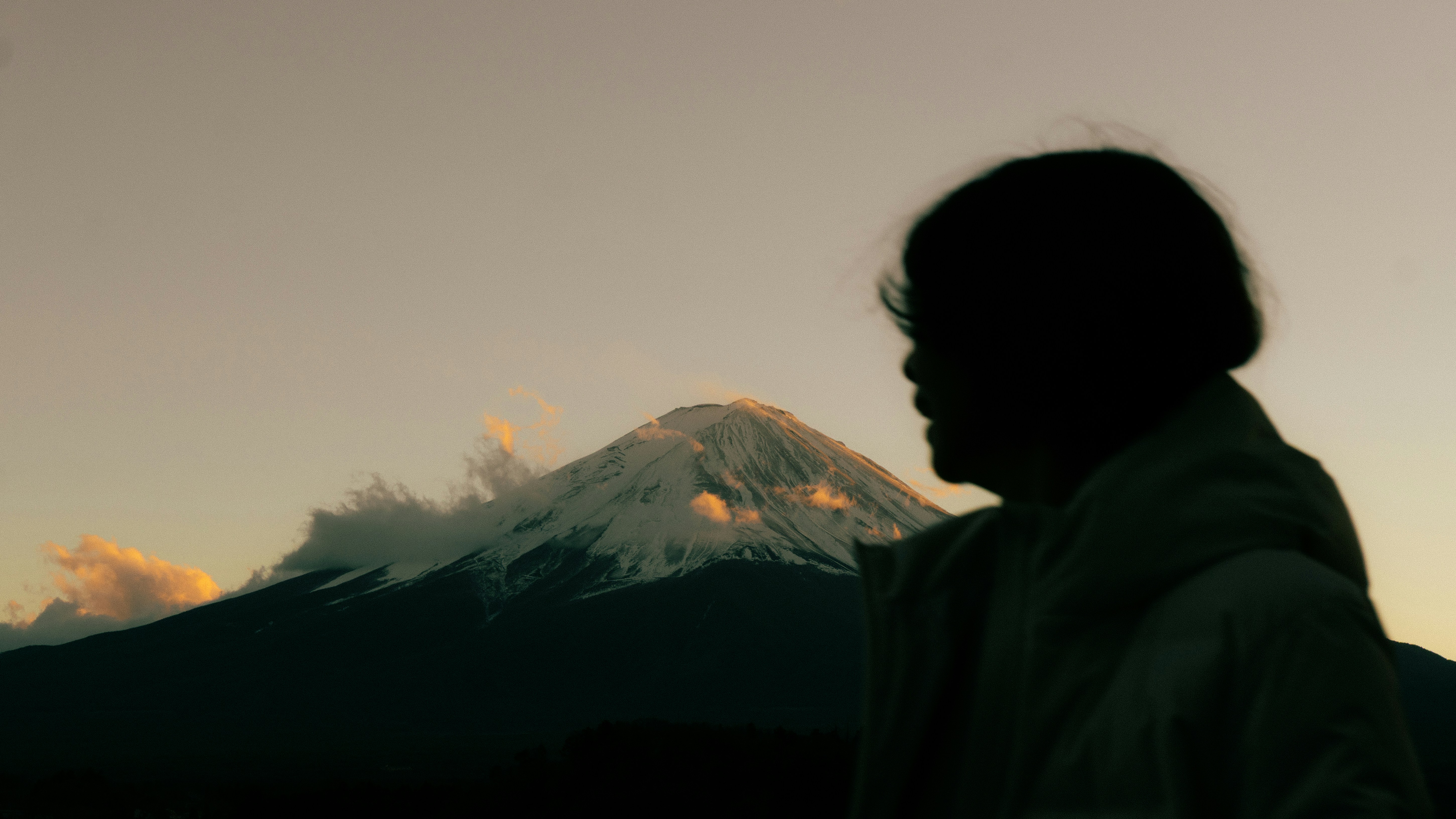 Silhouette at Dusk: Mountain Backdrop and Quiet Observer