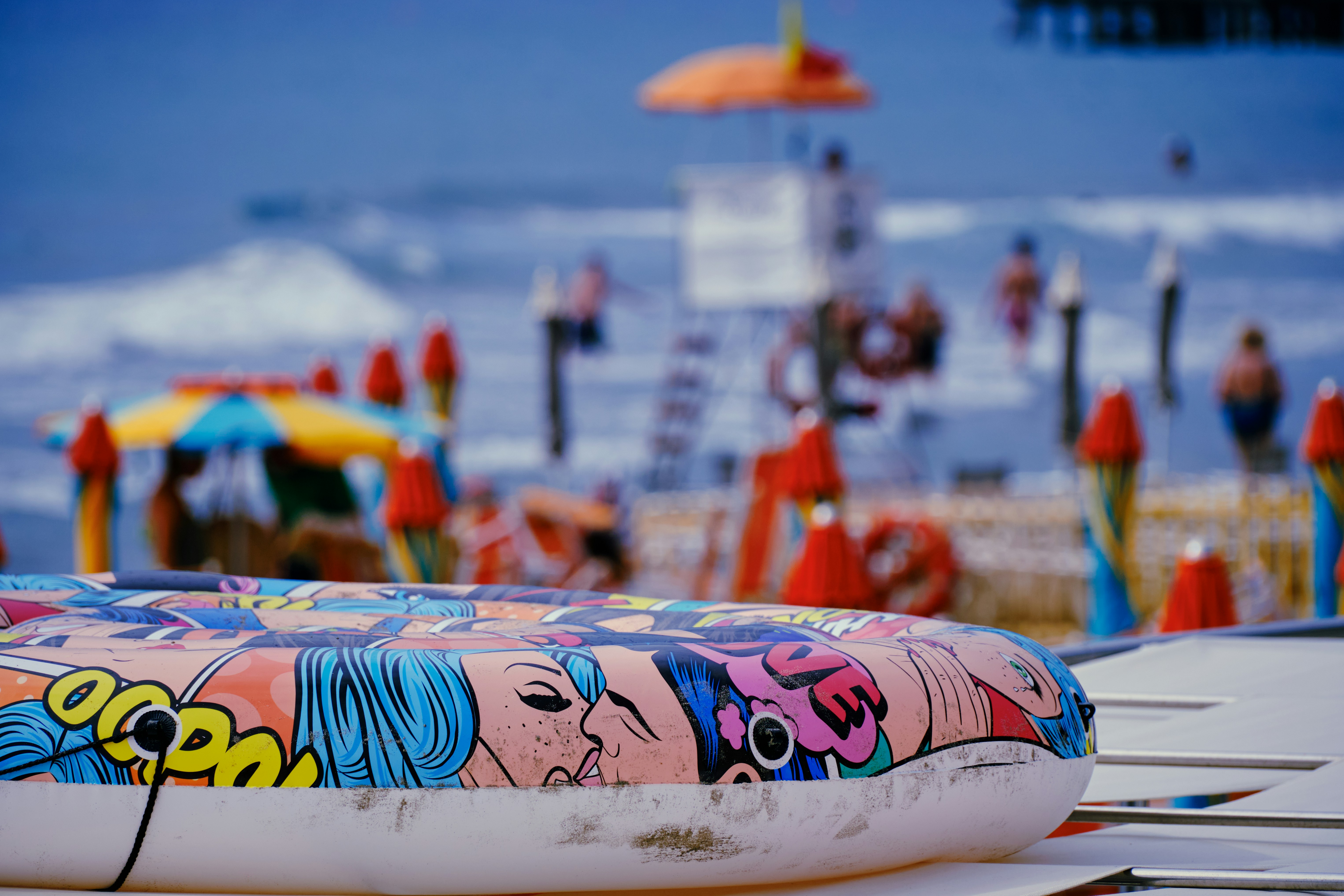 Pop Art Surfboard Looms Over a Busy Beach Scene