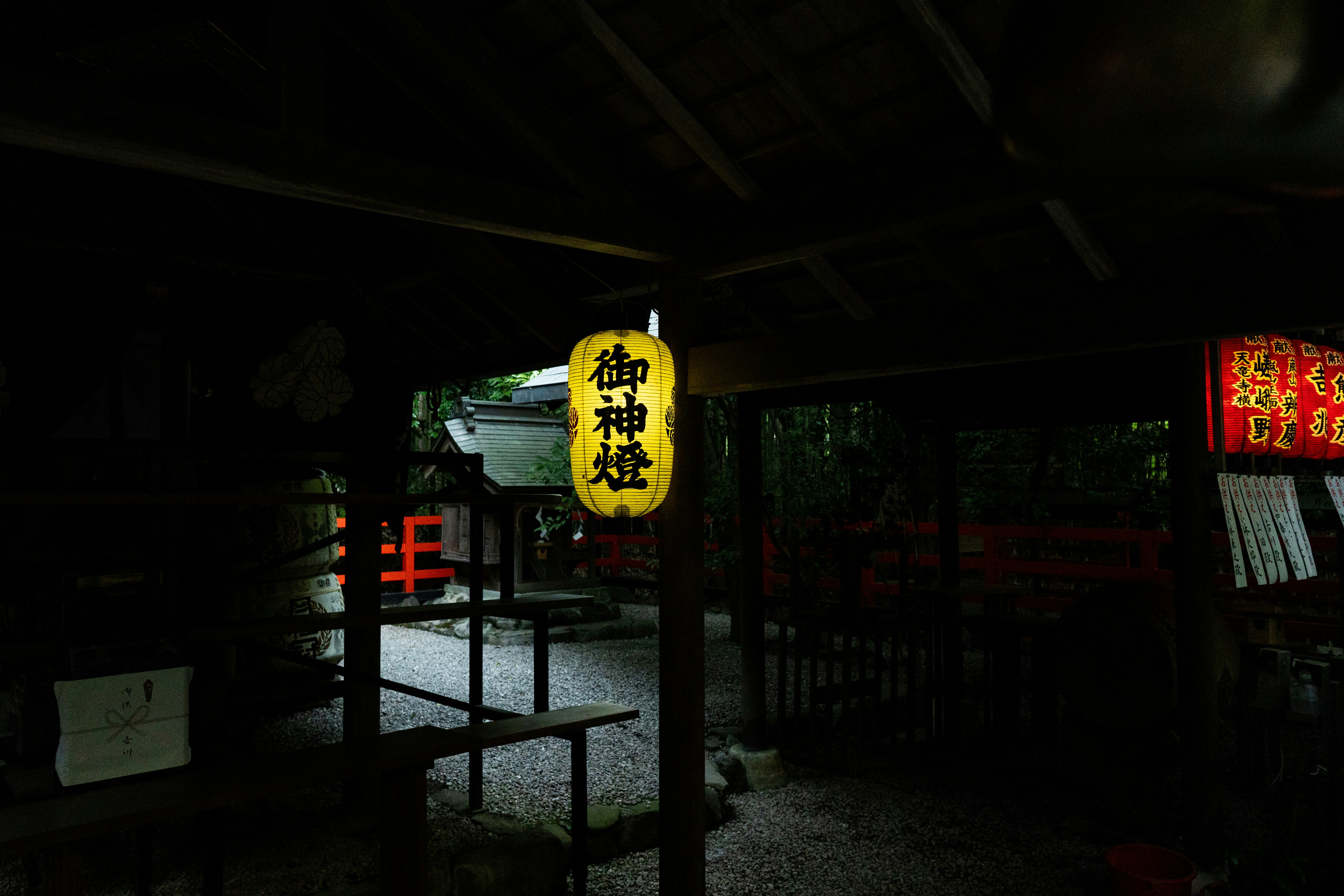 Traditional japanese lantern lights a shadowy temple interior.