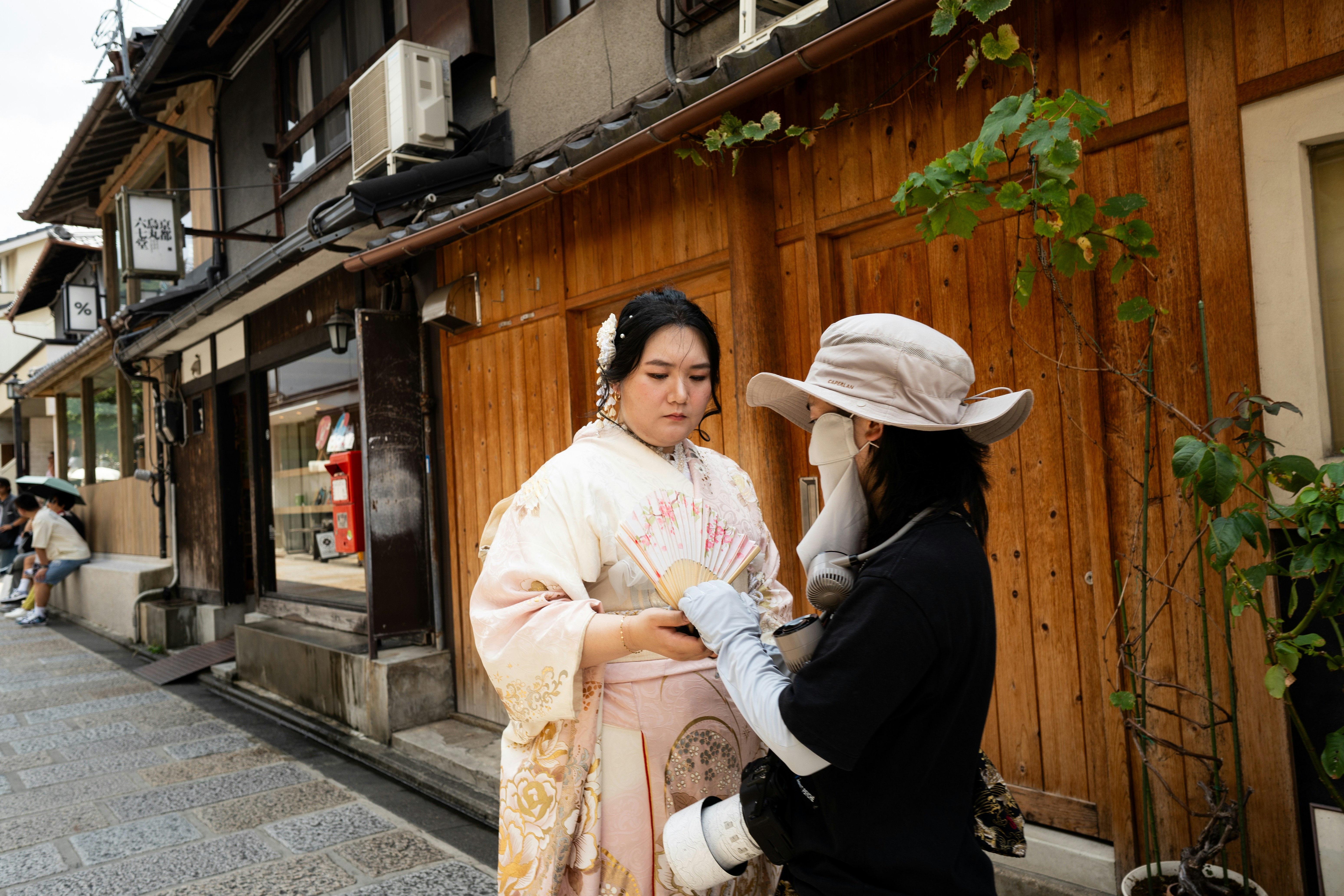 Kimono Exchange Under Ochre Wooden Facade