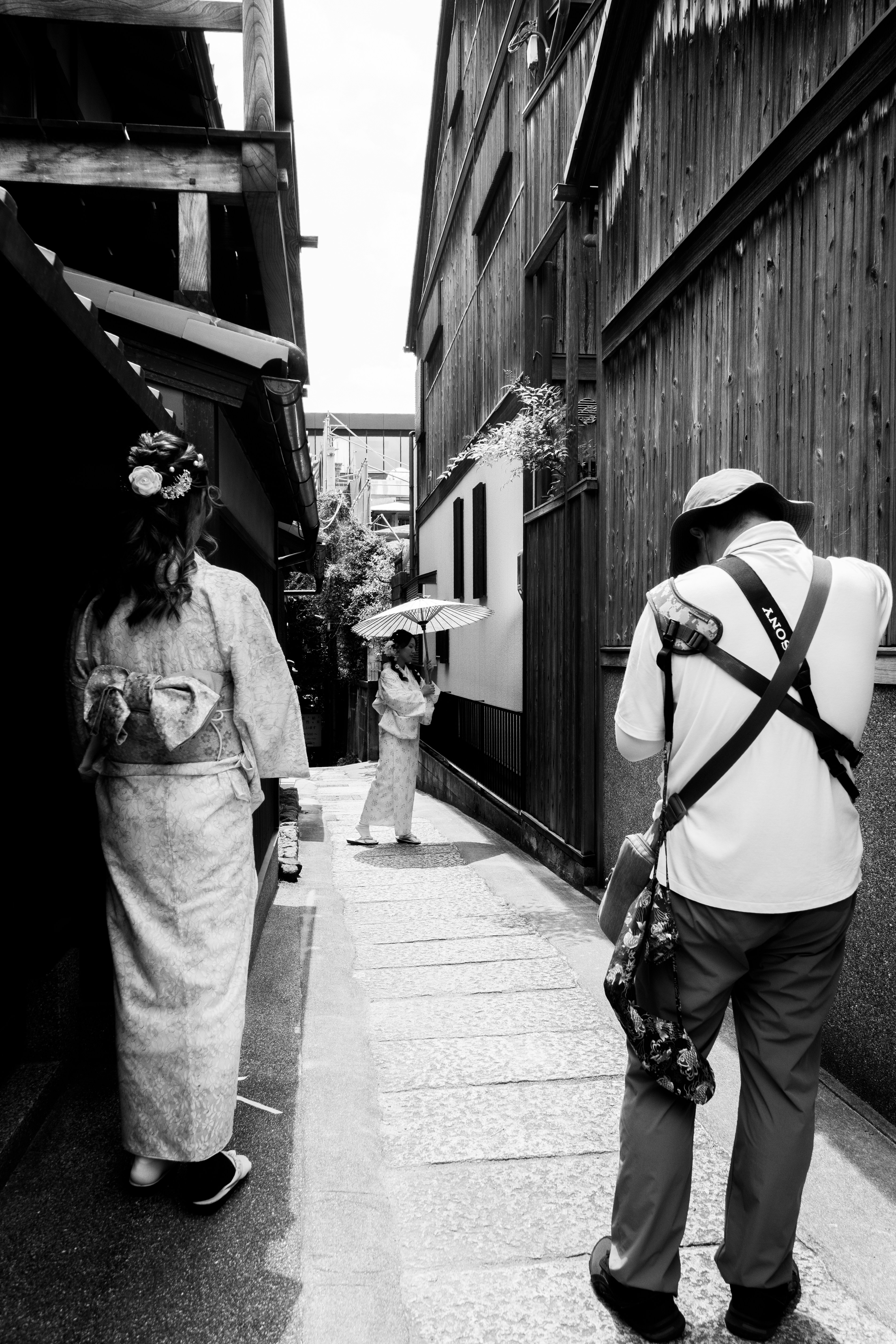 Ghosts of the Alley: Two Figures and a Floating Umbrella