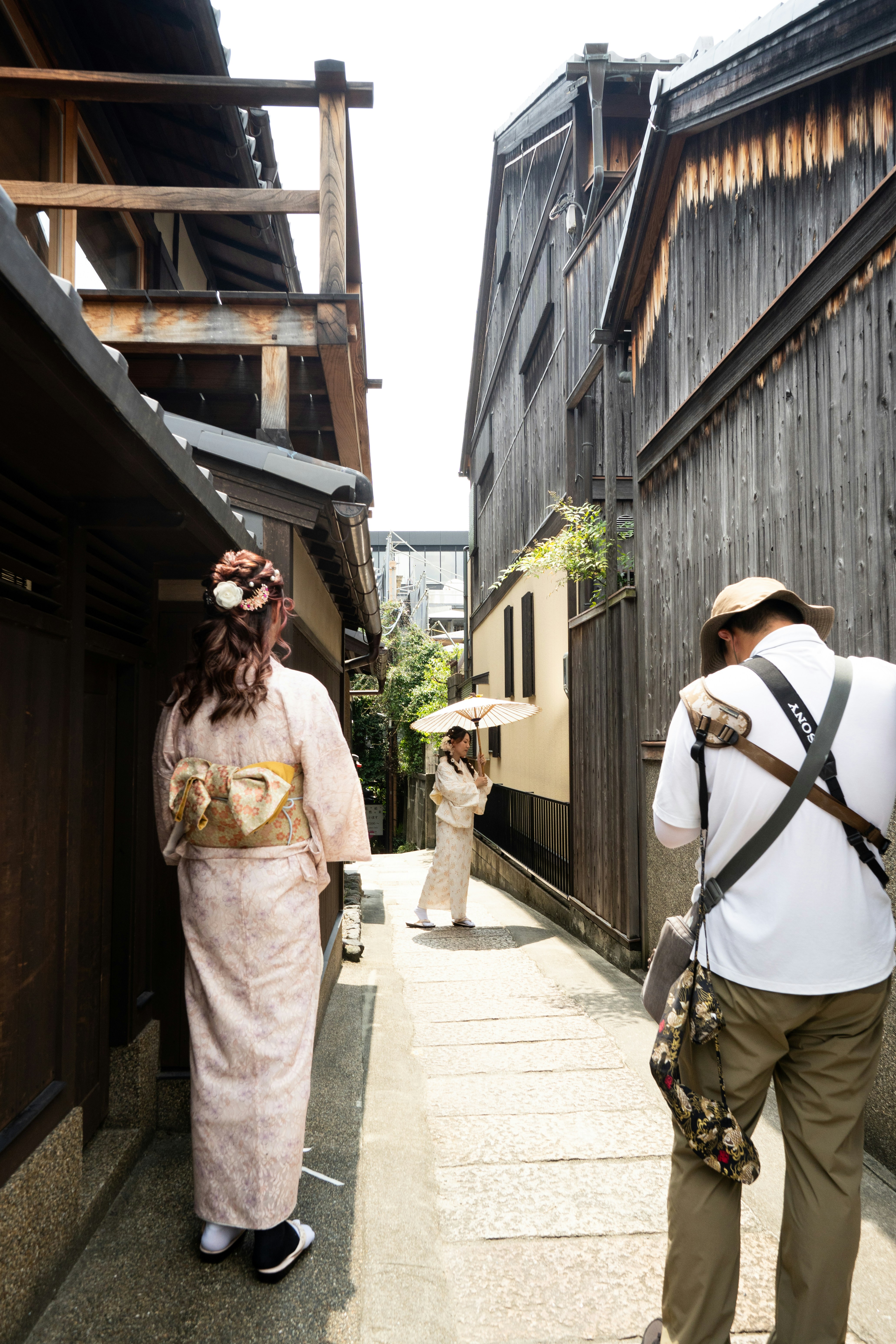 Photographer captures women in kimonos in a historic japanese alley.