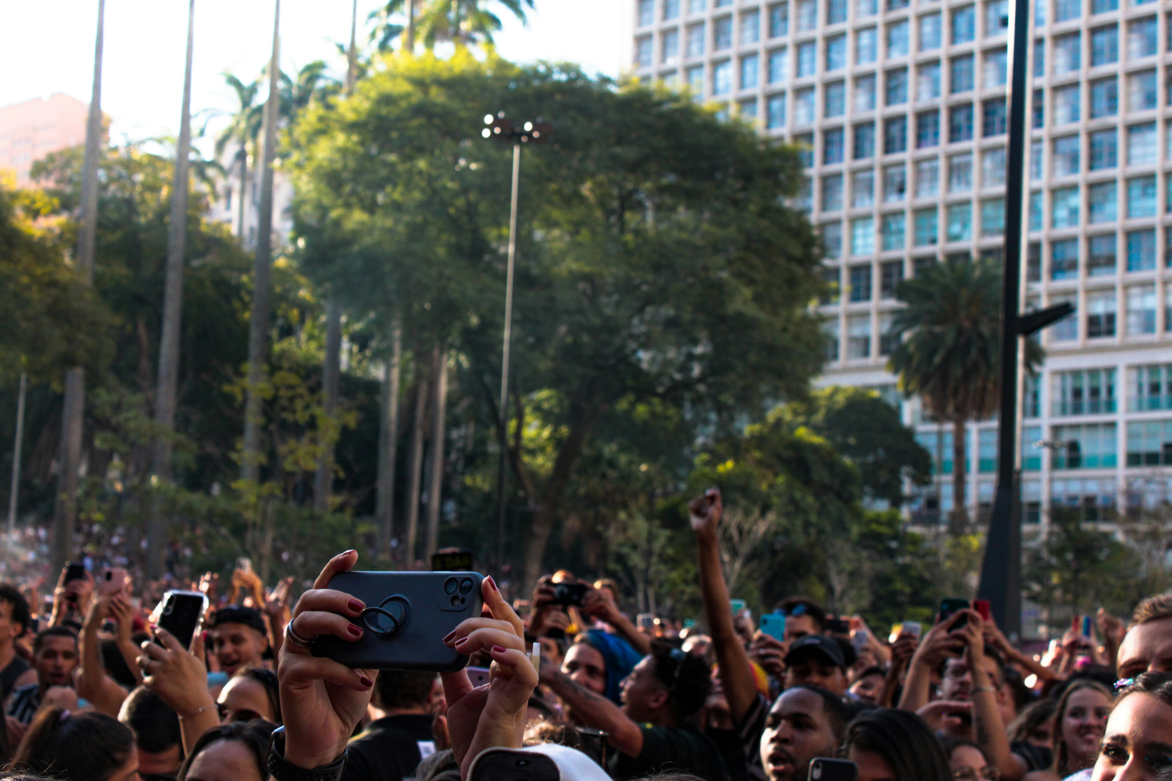 The Crowd Captured: Phone Screens and Raised Voices Under City Light