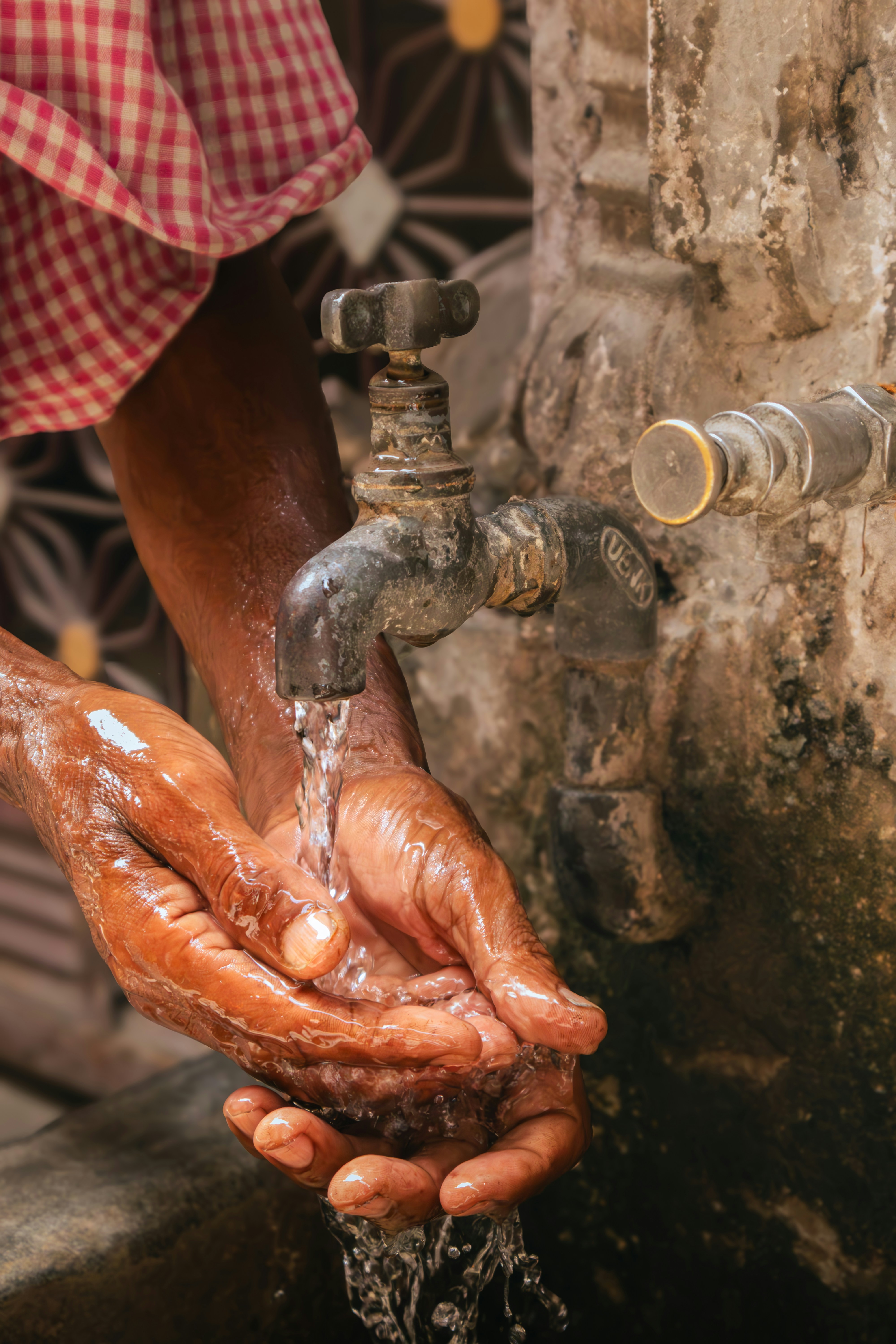 Washing Hands Under a Rustic Tap: Water, Dirt, and Care