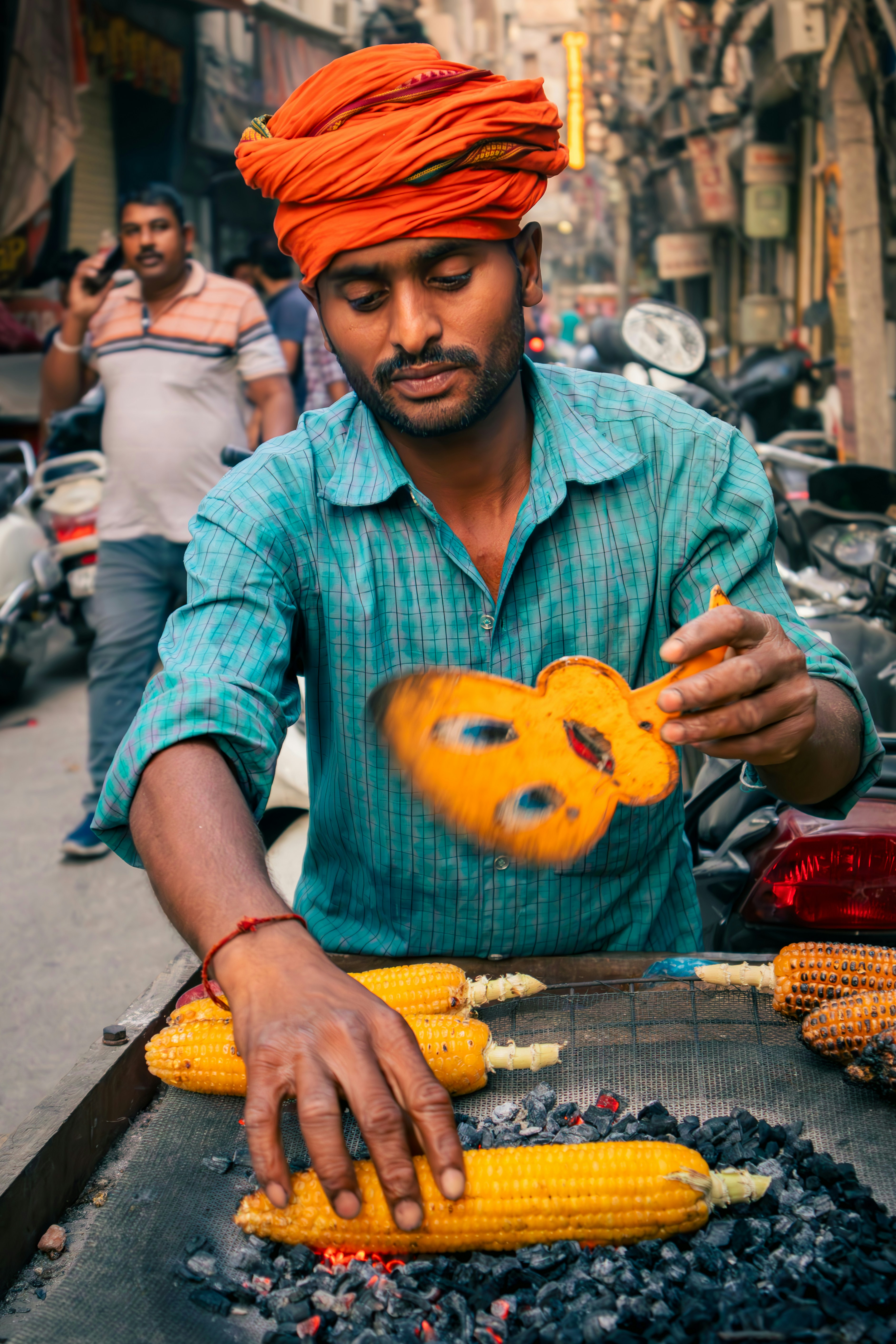 Street Vendor in Turban Grilling Corn with a Mask for Sale