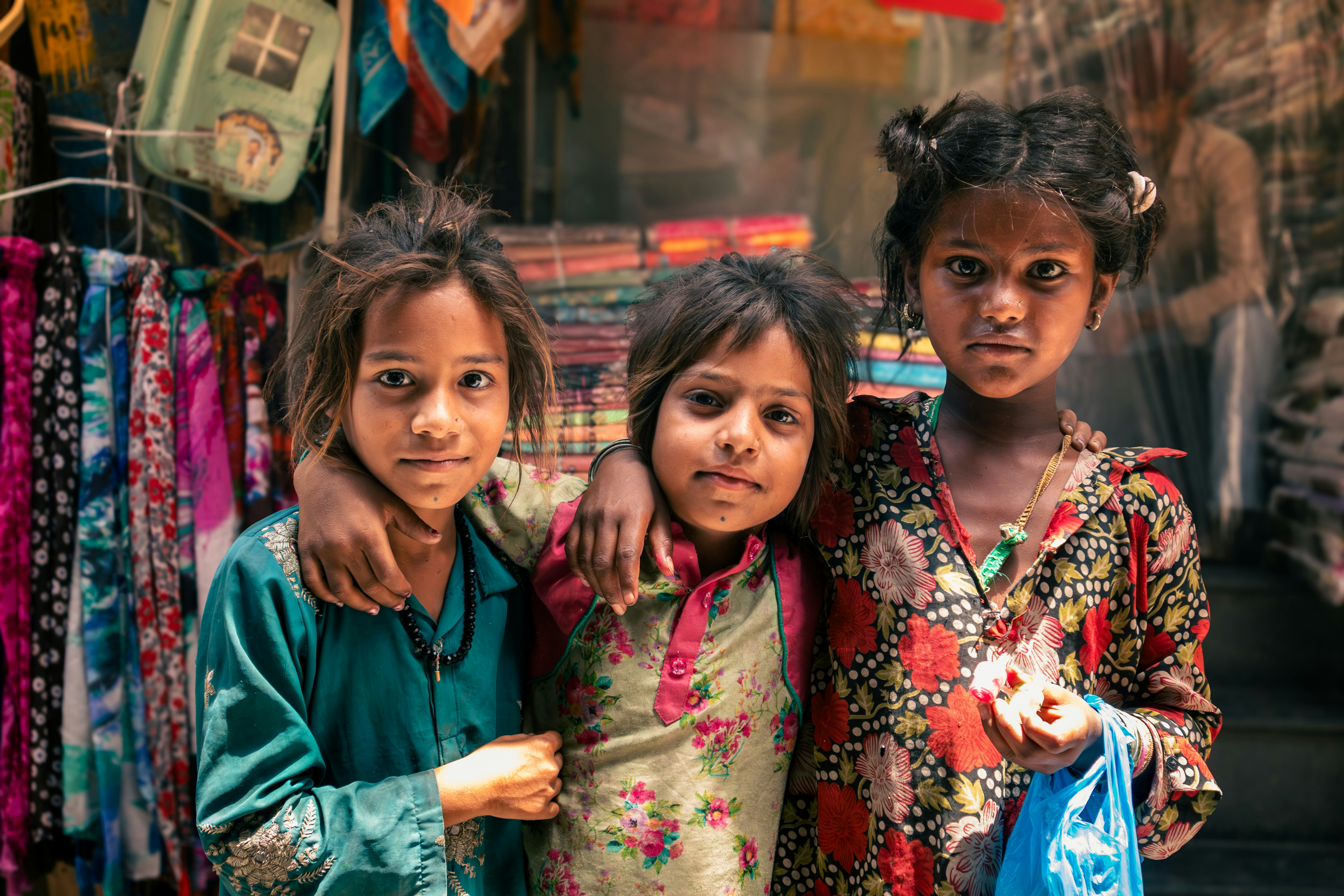 Three Friends, One Shared Moment in a Colorful Market Alley