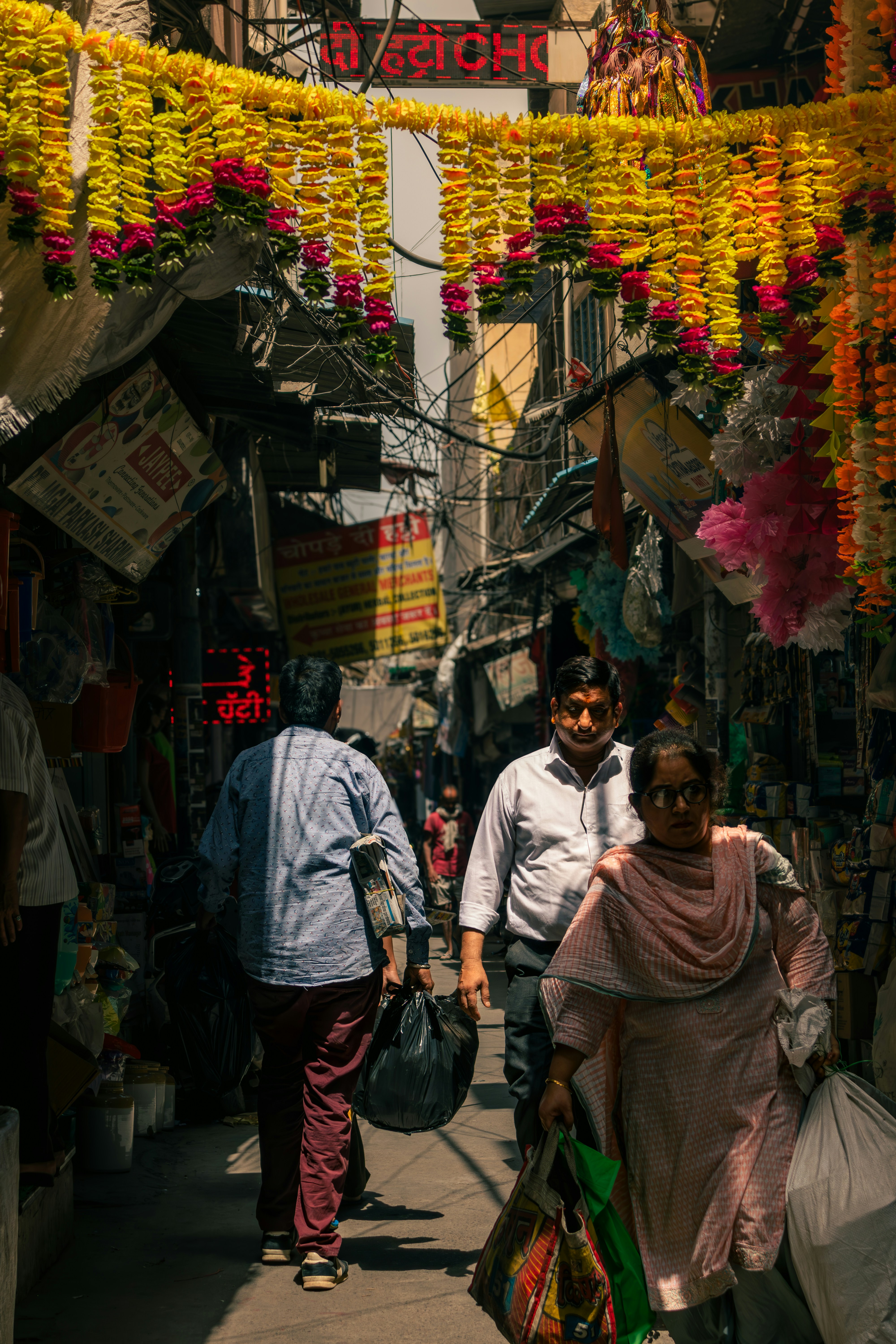 A Narrow Bazaar Framed by Marigold Garlands