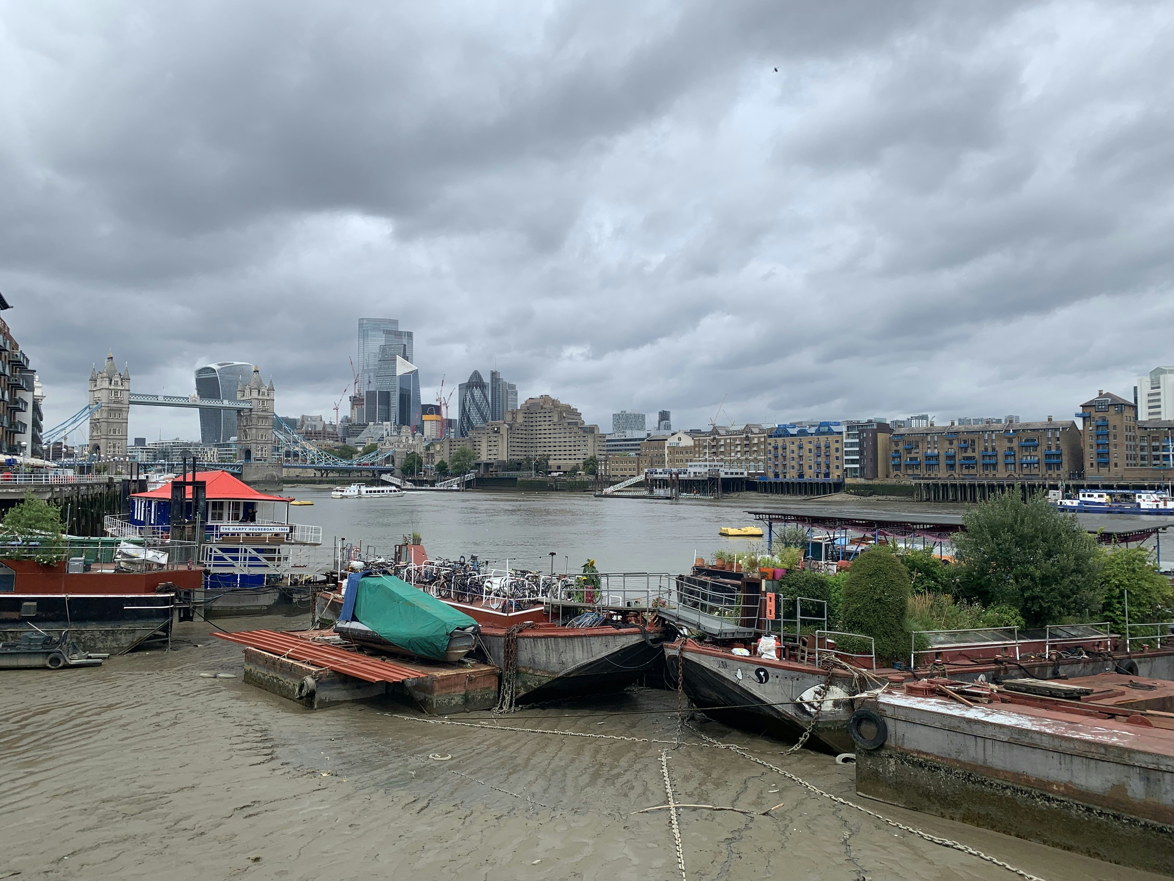 London Riverside: Boats, Tower Bridge Silhouette, and a Stormy Sky