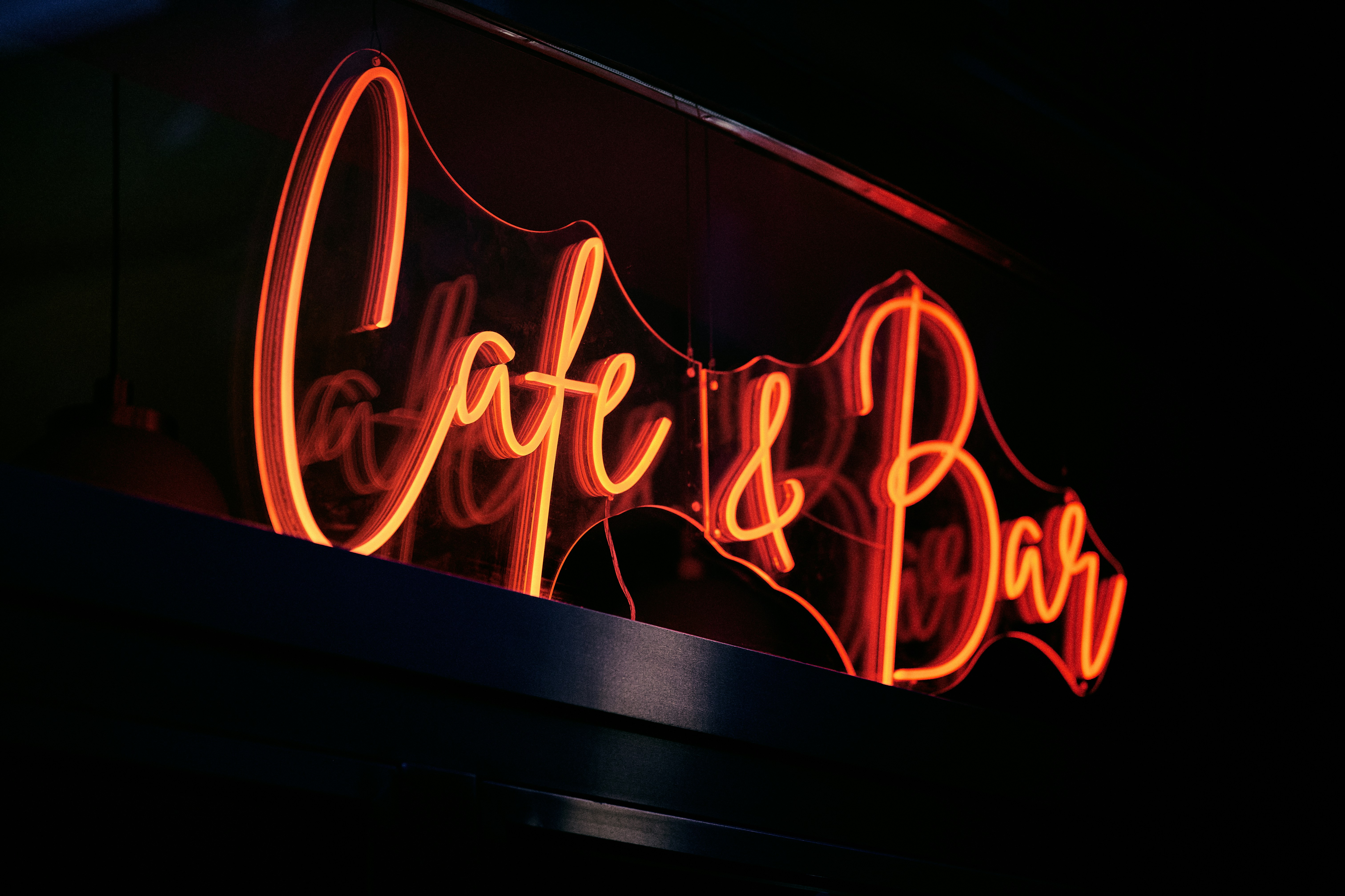 Neon Glimmer Over Dark Bar: Cafe & Bar Sign in Red