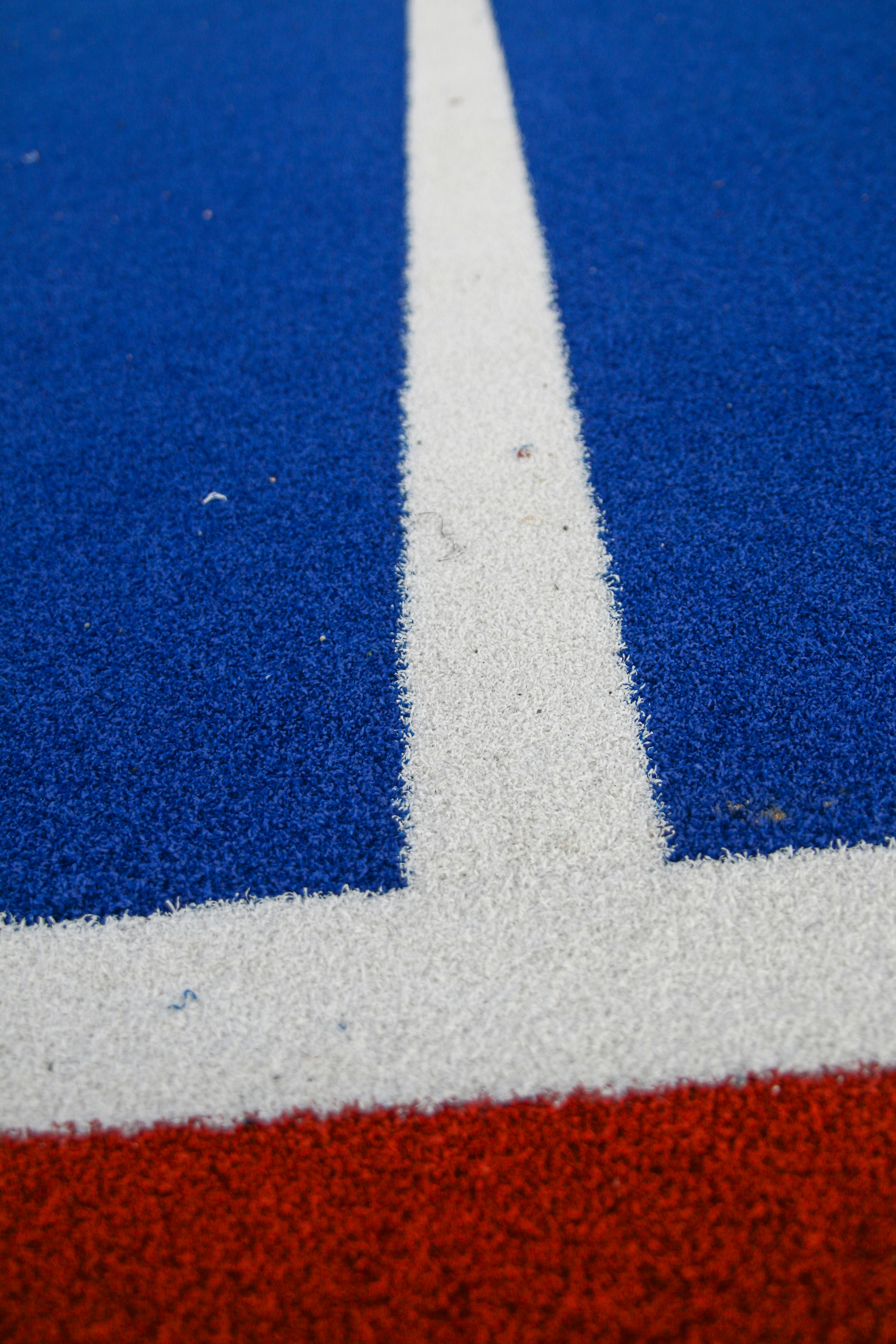 Bright White Lane on a Blue Track: A Close-Up of Boundary Lines
