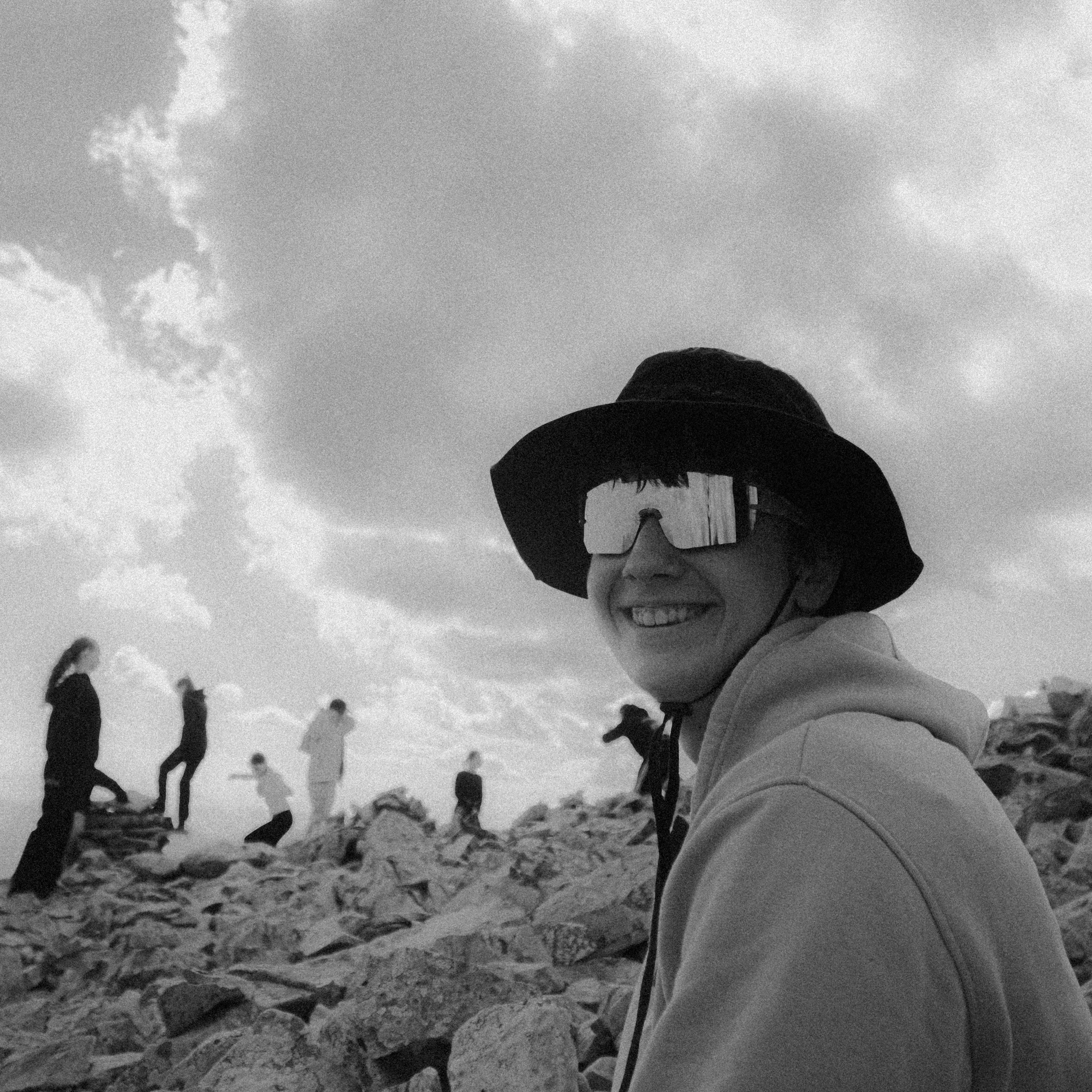 Smiling Explorer with Reflective Goggles on a Wind-Swept Ridge