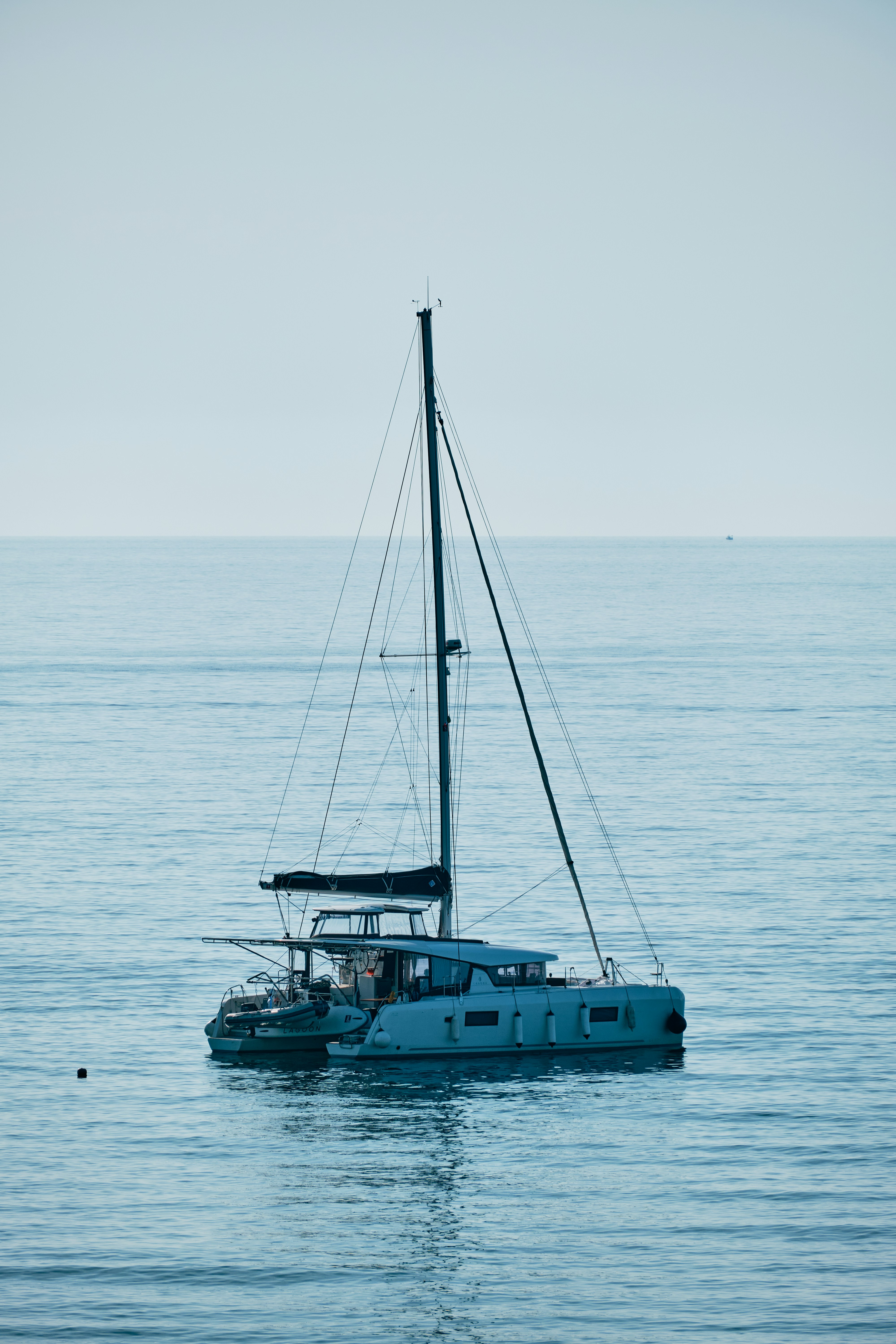 Sailing Solitude: A Lone Catamaran Resting on Quiet Seas