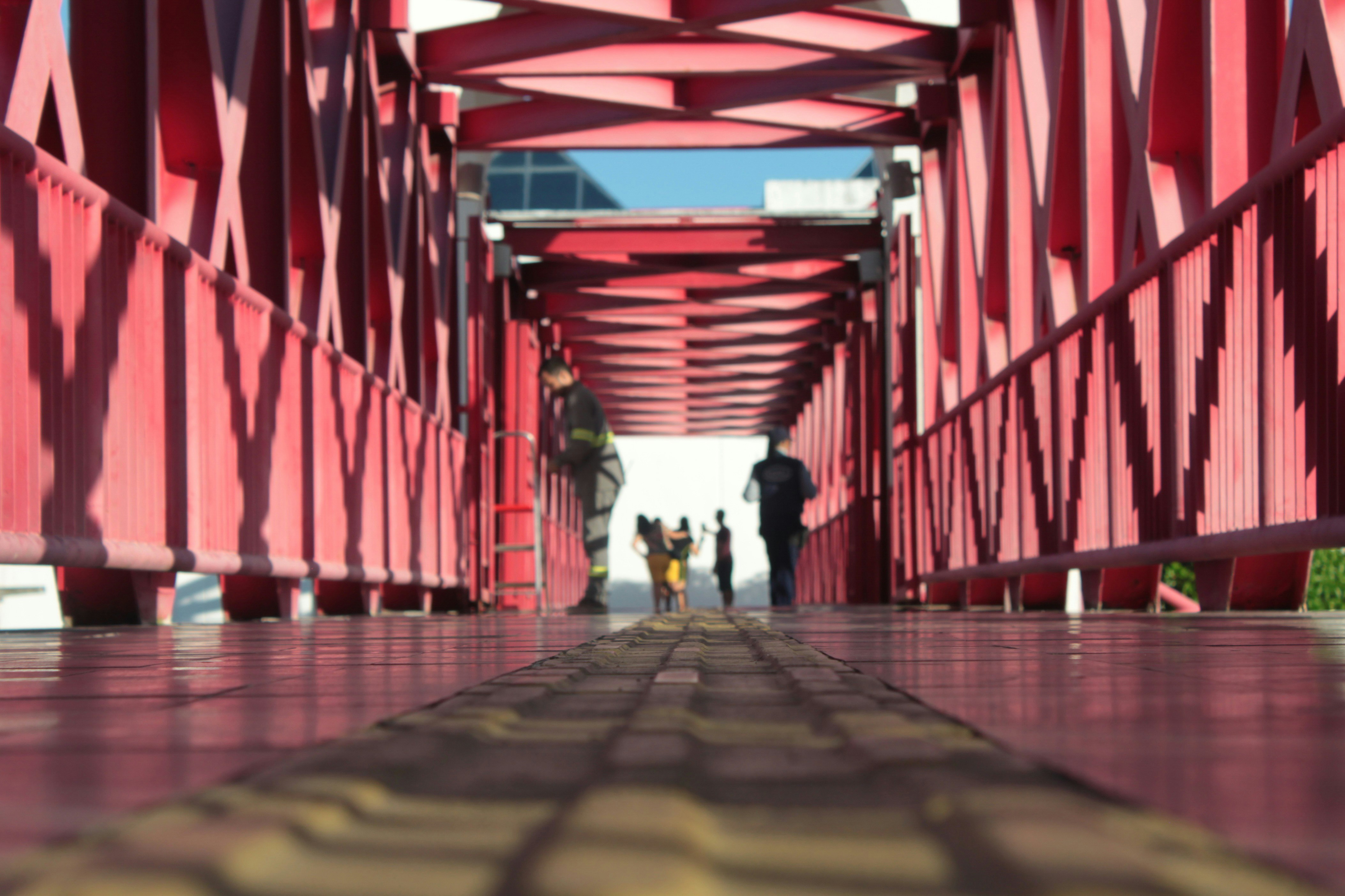 Pedagogical Perspective: People at the End of a Red Bridge Corridor