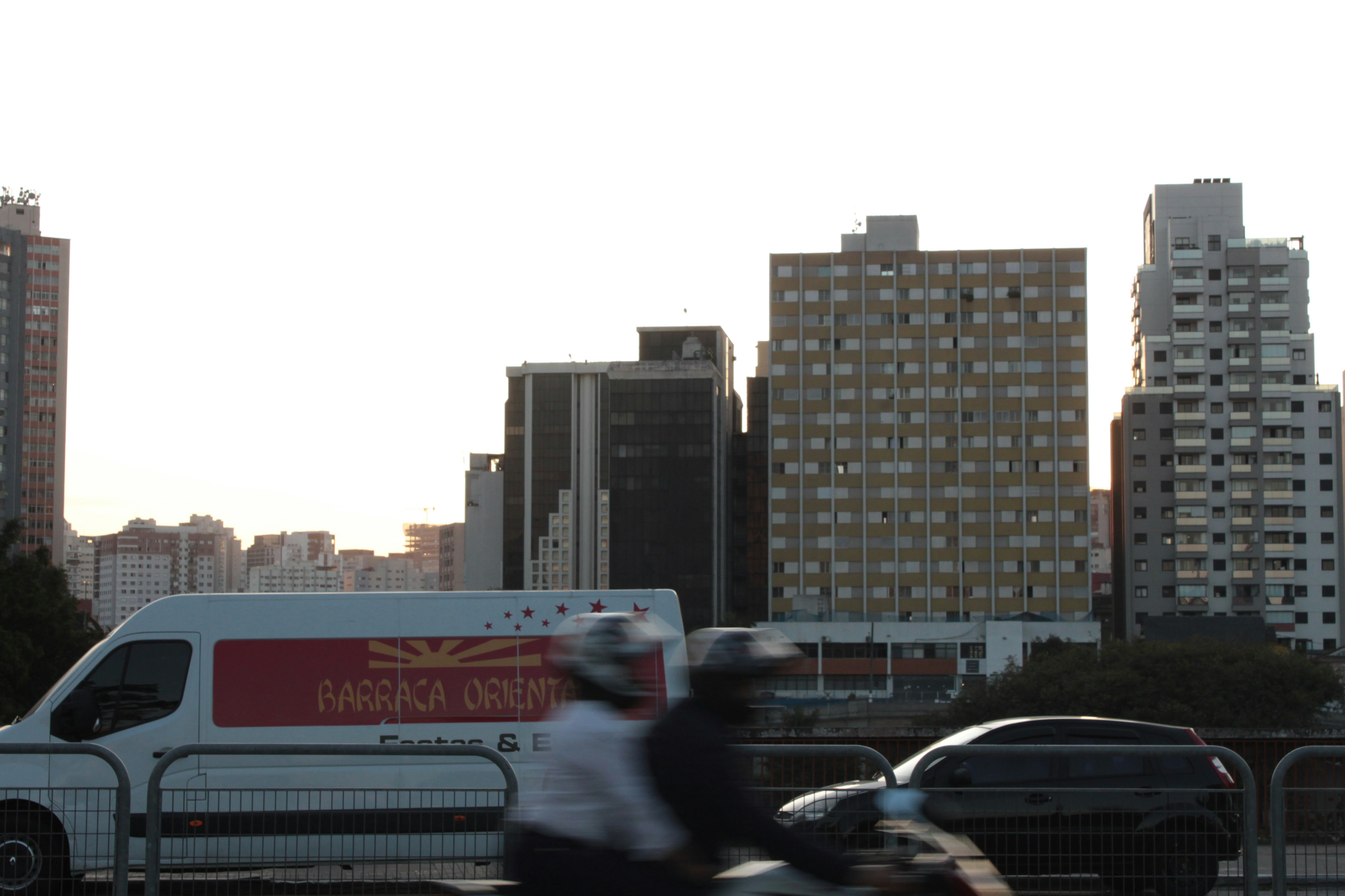 Cityscape in motion: buses and silhouettes against a rising sun