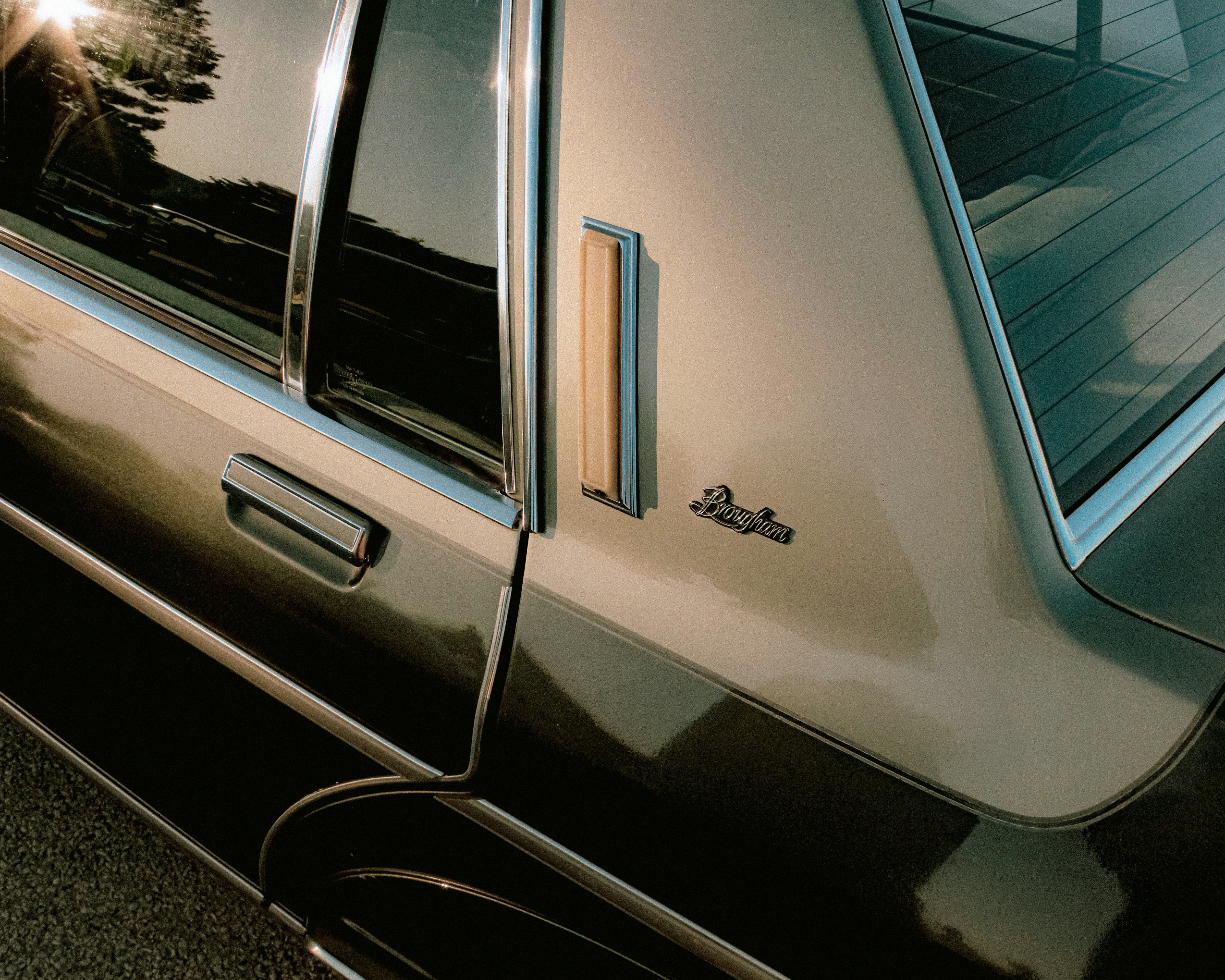 Chrome trim and badge glow on a classic car’s rear corner