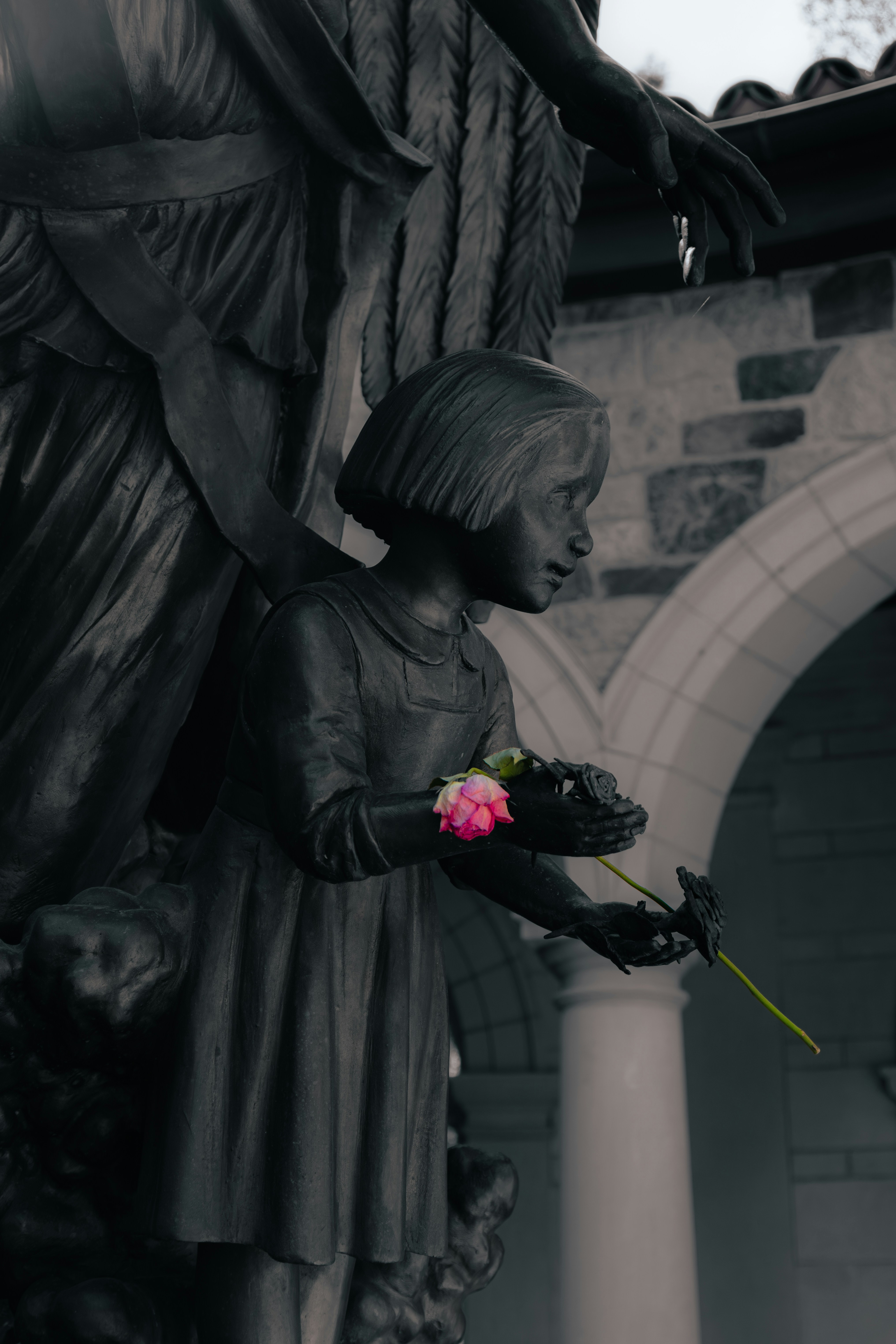 Offering a Pink Flower: A Quiet Moment Beneath a Monumental Gesture