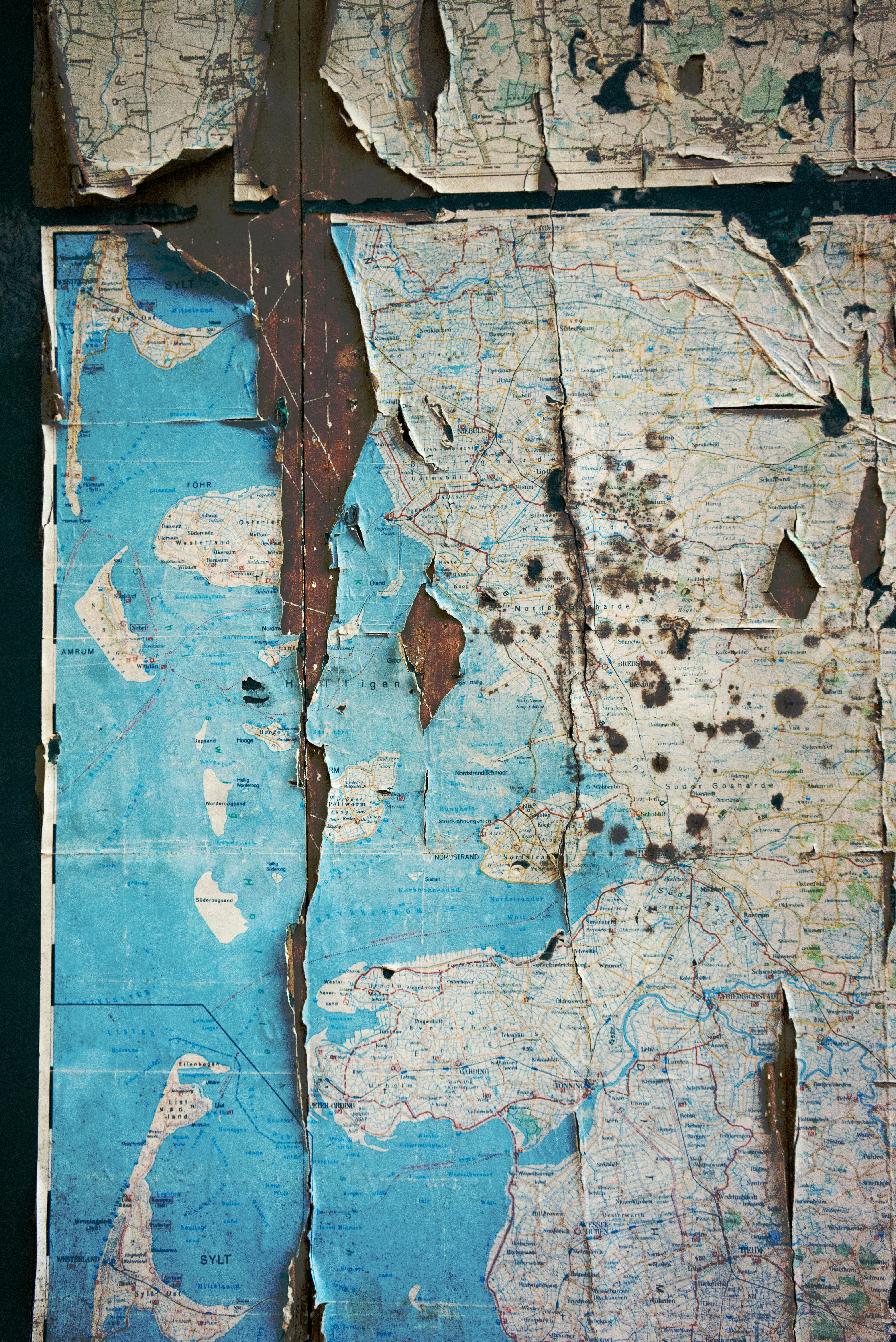 Weathered Cartography: Cracked Maps on a Timeworn Wall