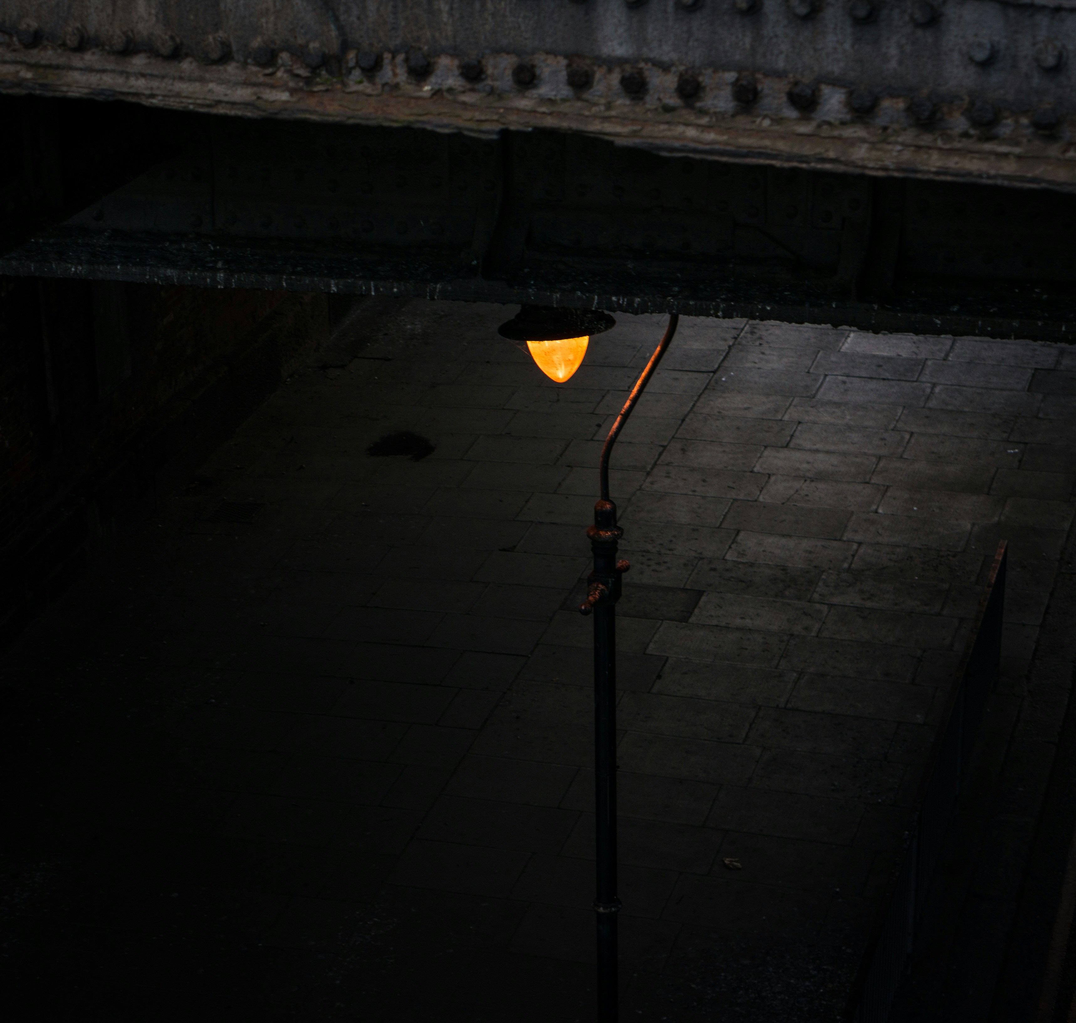 A Lone Streetlamp Under the Rail Arch