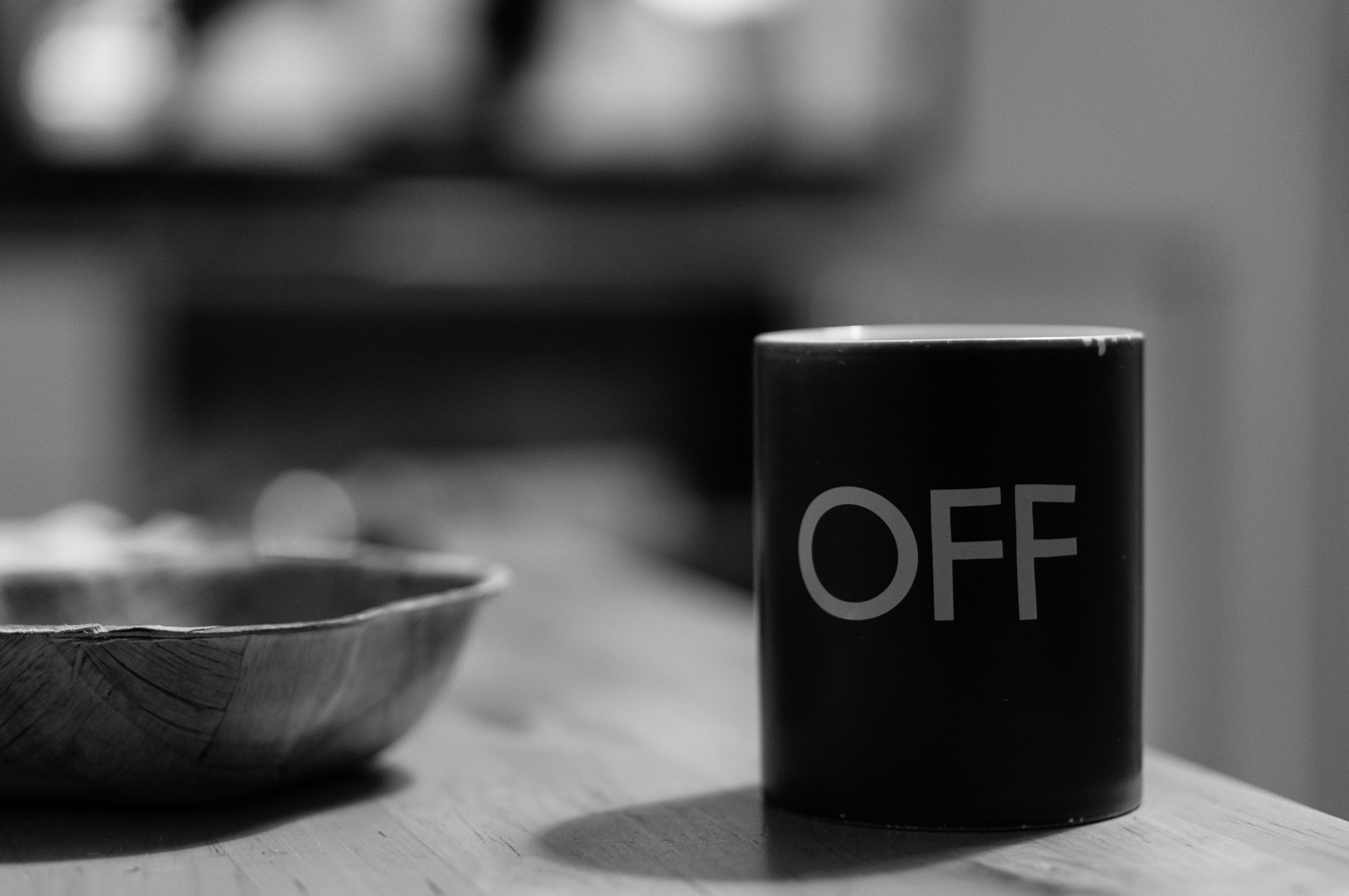 A black cylinder with "off" next to a wooden bowl.