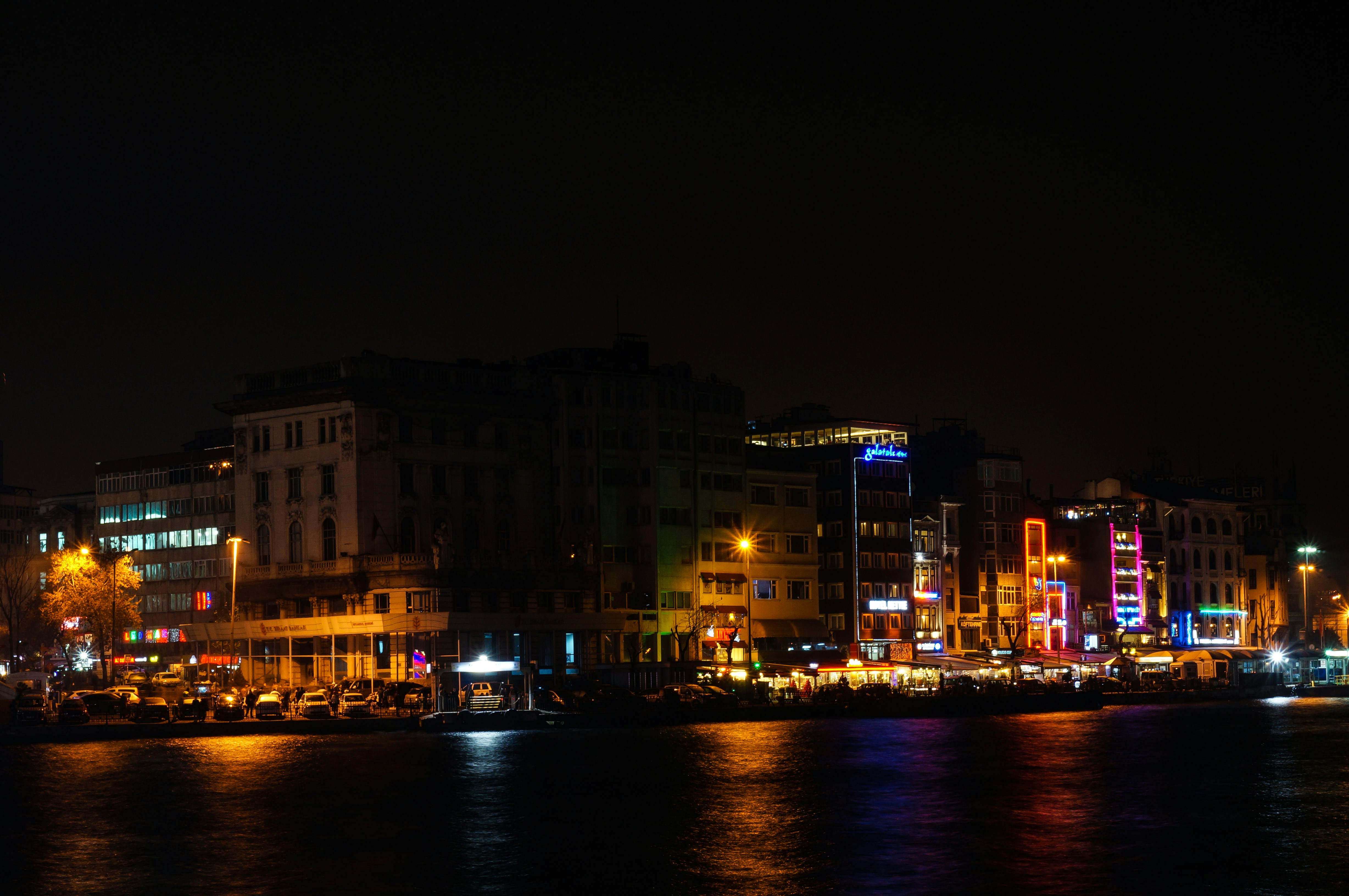 Neon Waterfront: A Night of Reflections along a Quiet Harbor