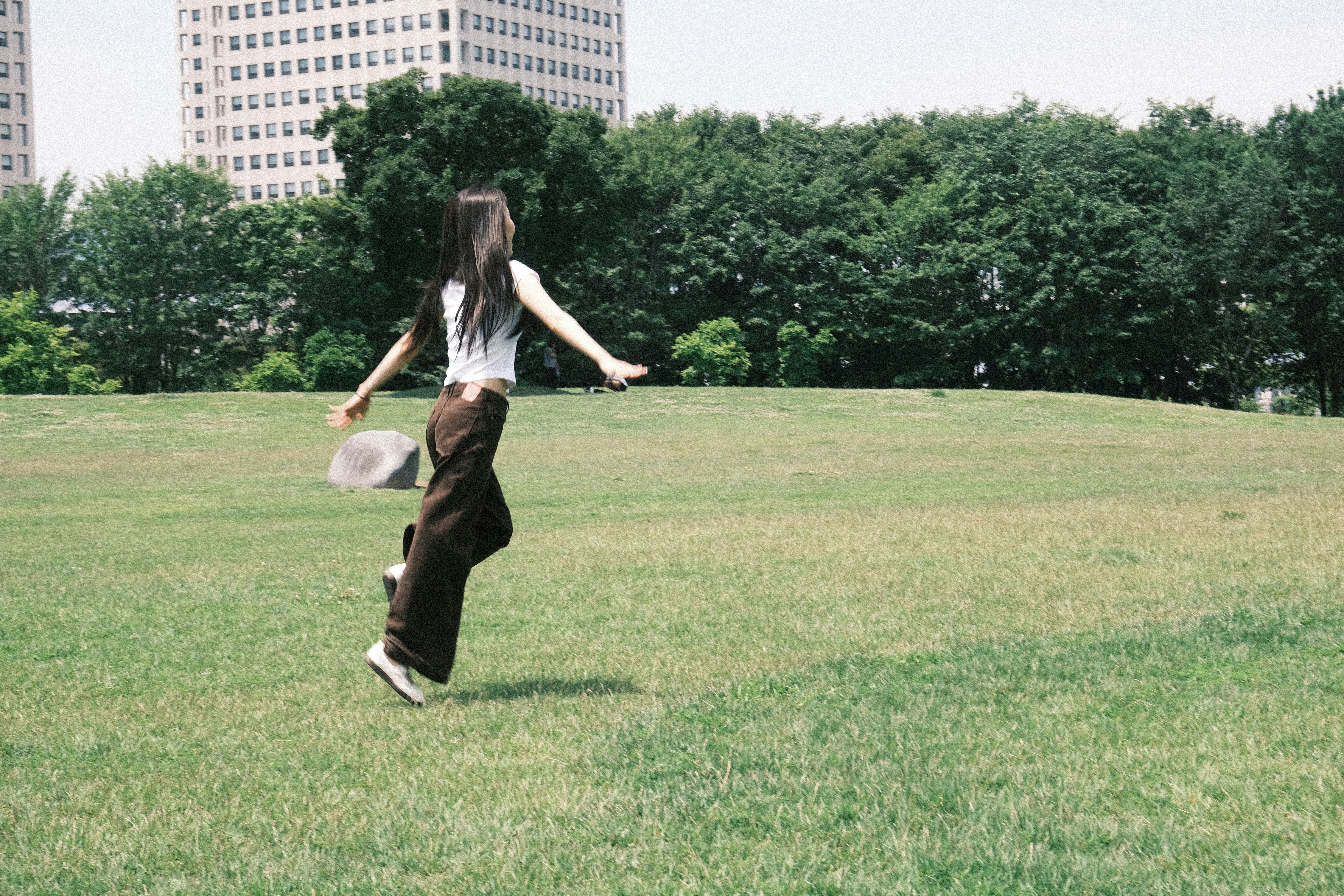 Leap of Glee: A girl mid-air in an sunlit park