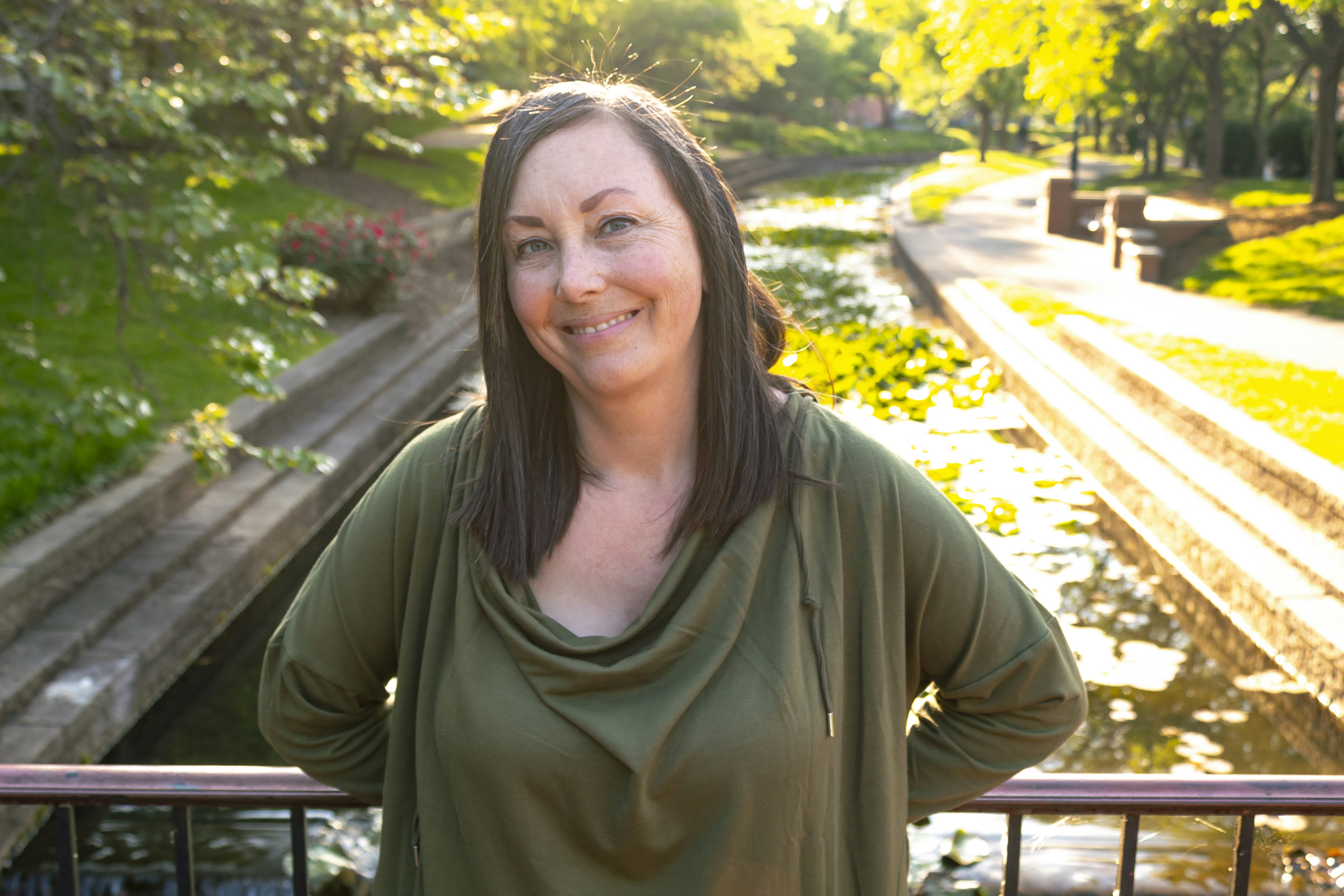 Sunlit Park Portrait: A confident smile by the canal rails