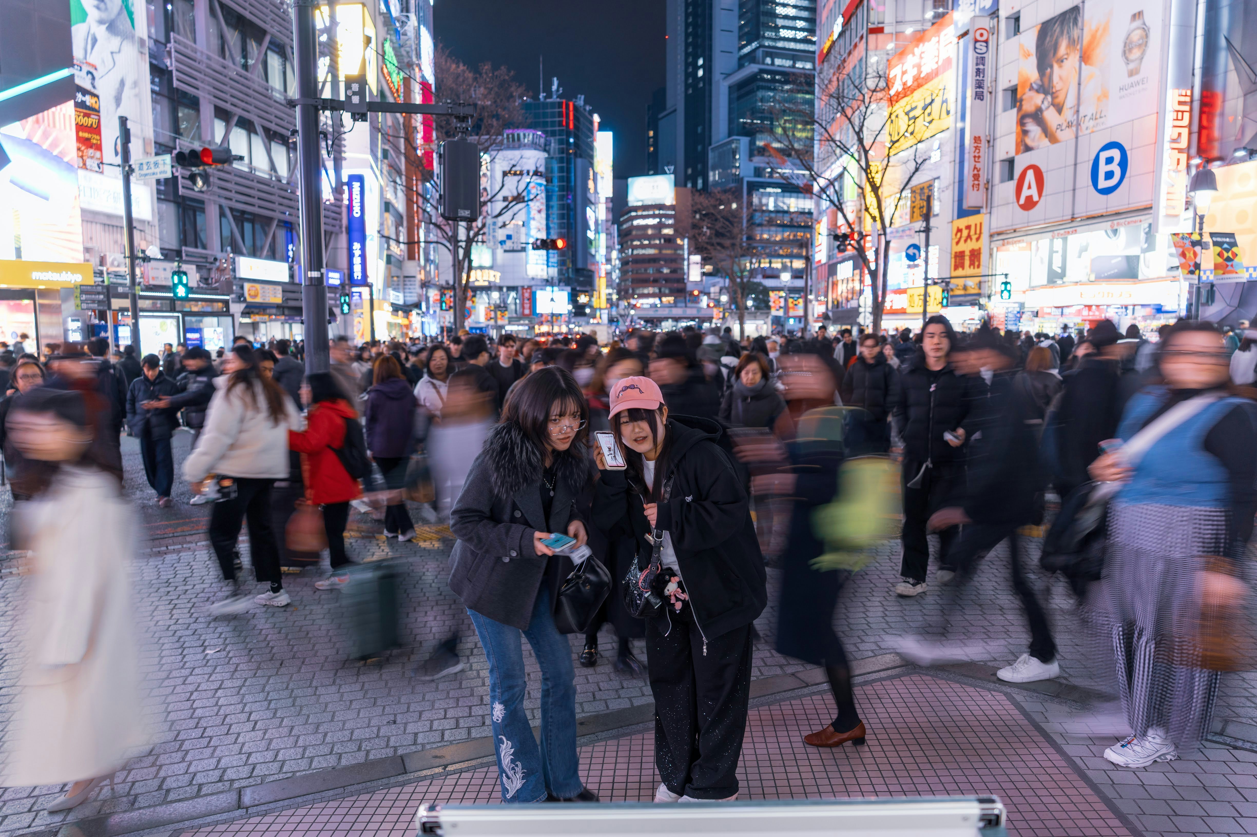 Two friends in a neon-lit crossroad: city pulse captured at dusk