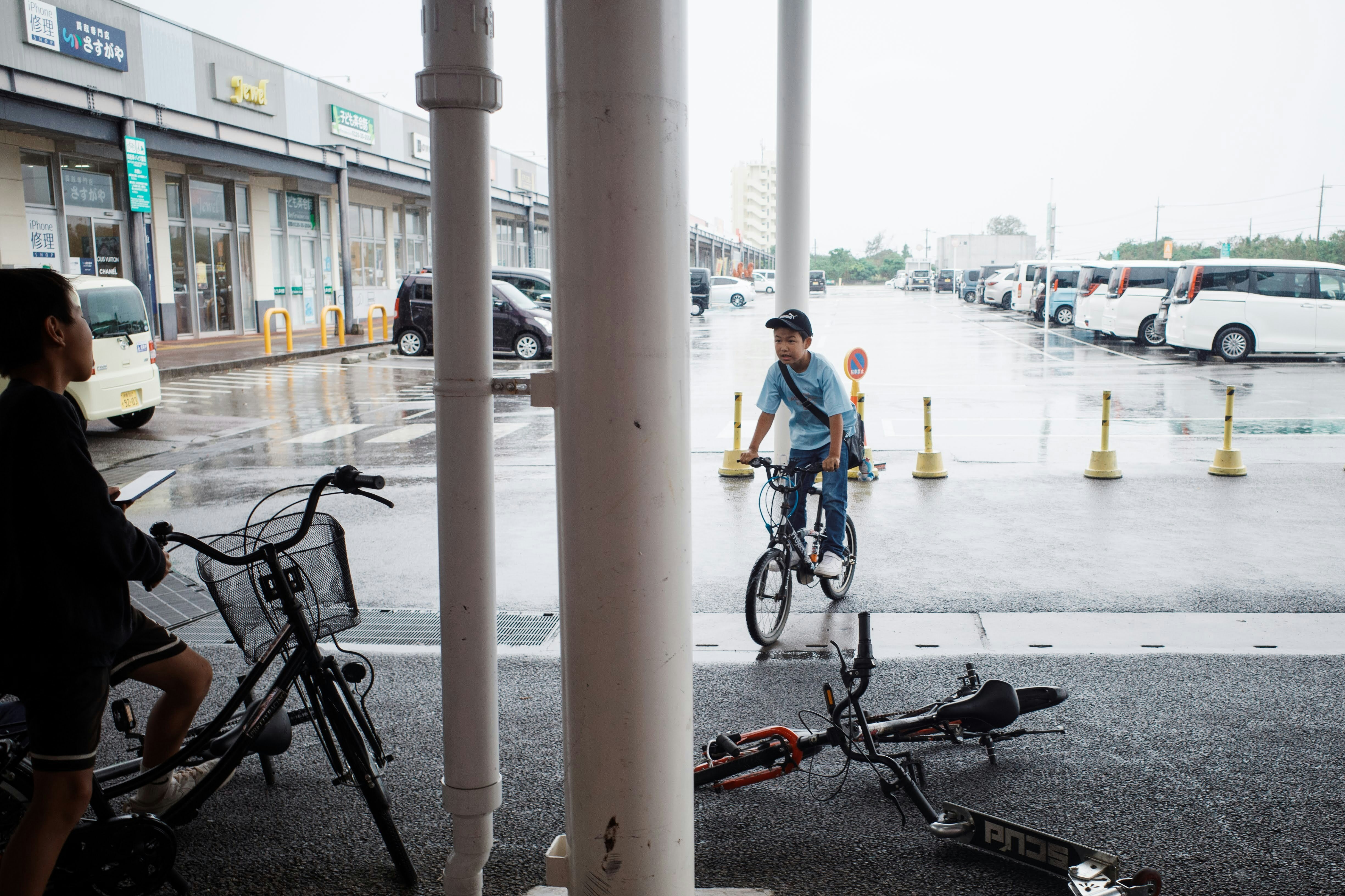 Two people and bicycles on a rainy street.