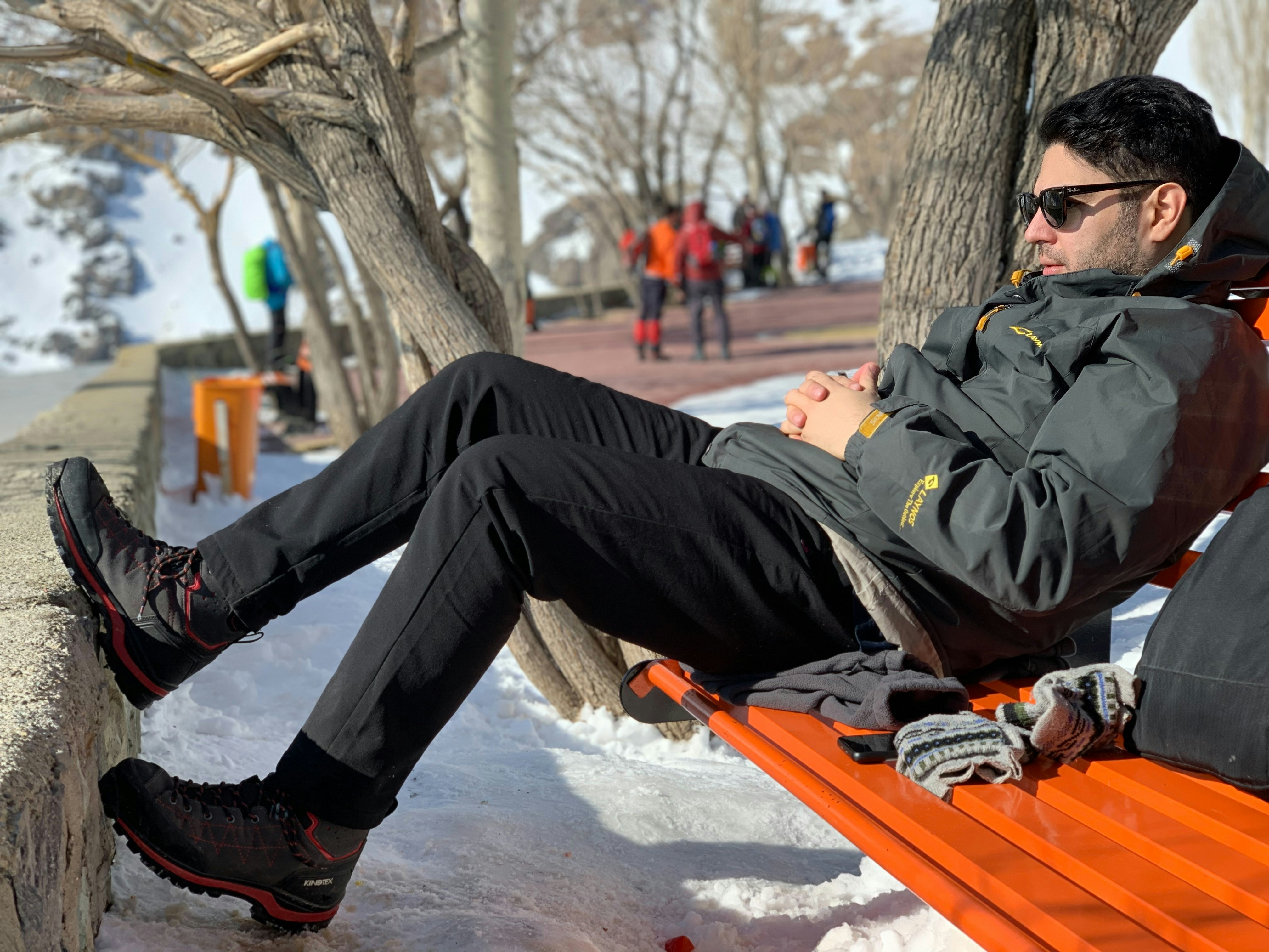 Sunlit Angles: A Reclined Traveler Resting on an Orange Snow Sled