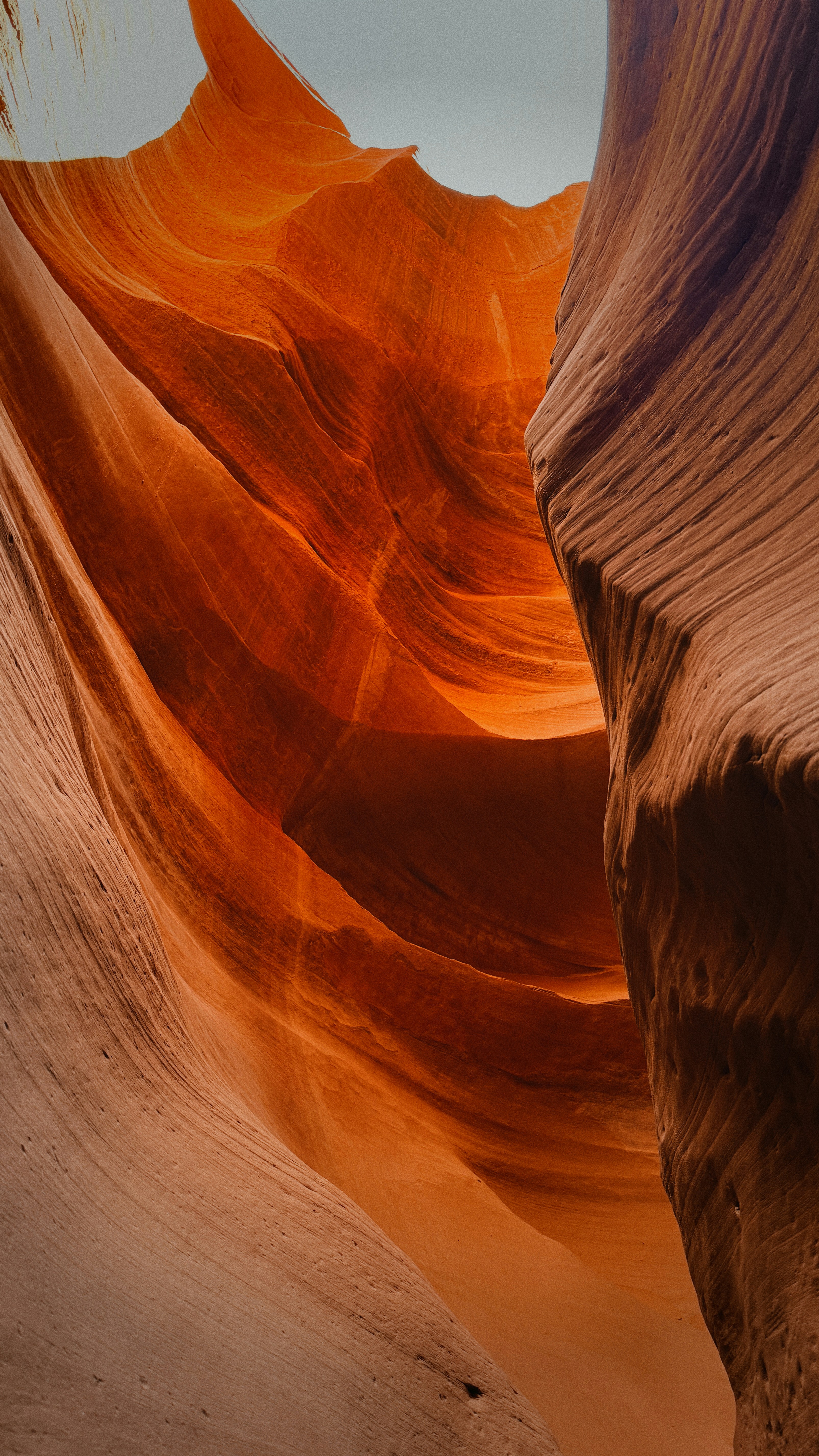 Swirling orange sandstone walls of a slot canyon.