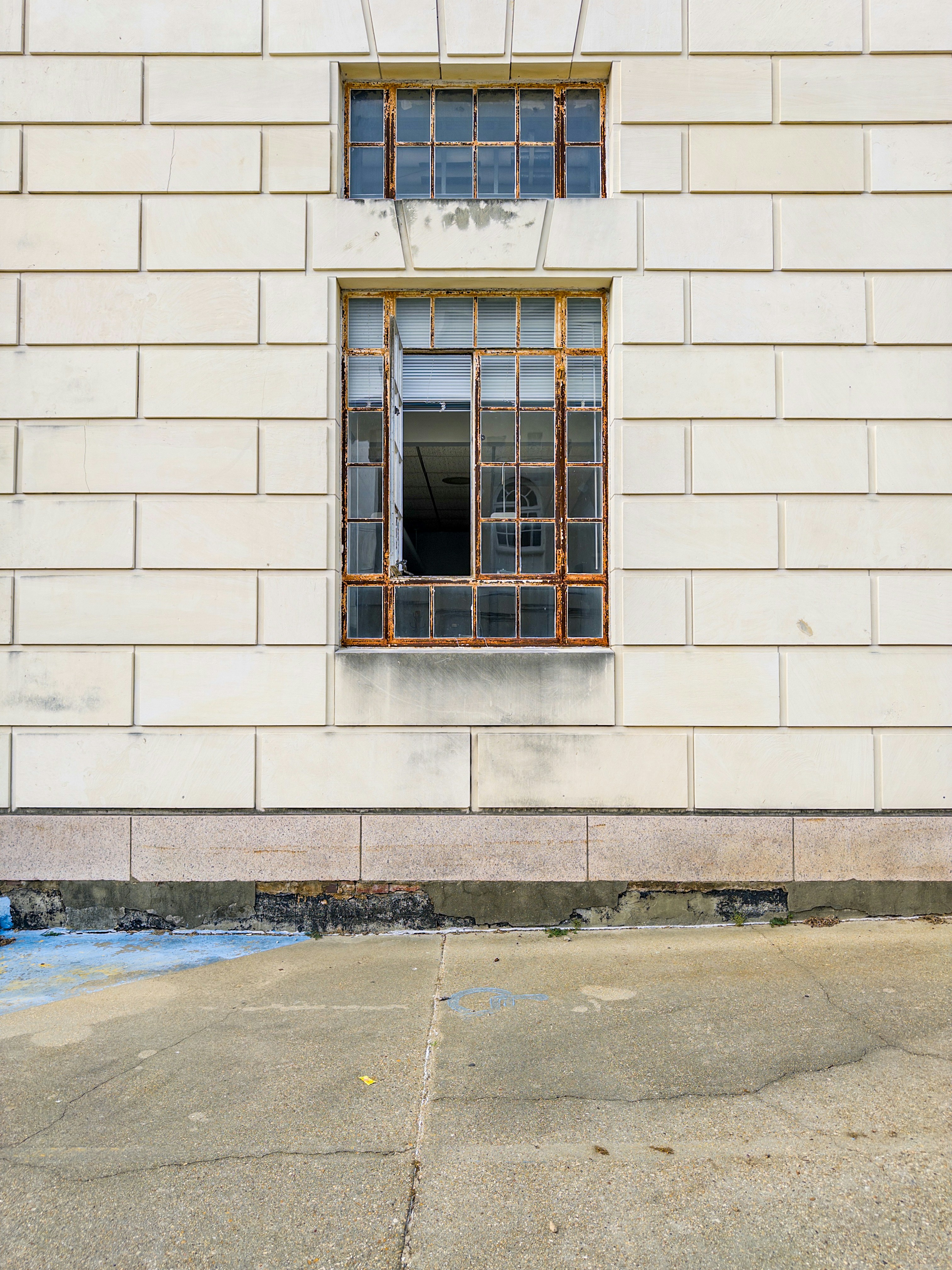 Rusty Window Grids on a Cream Facade