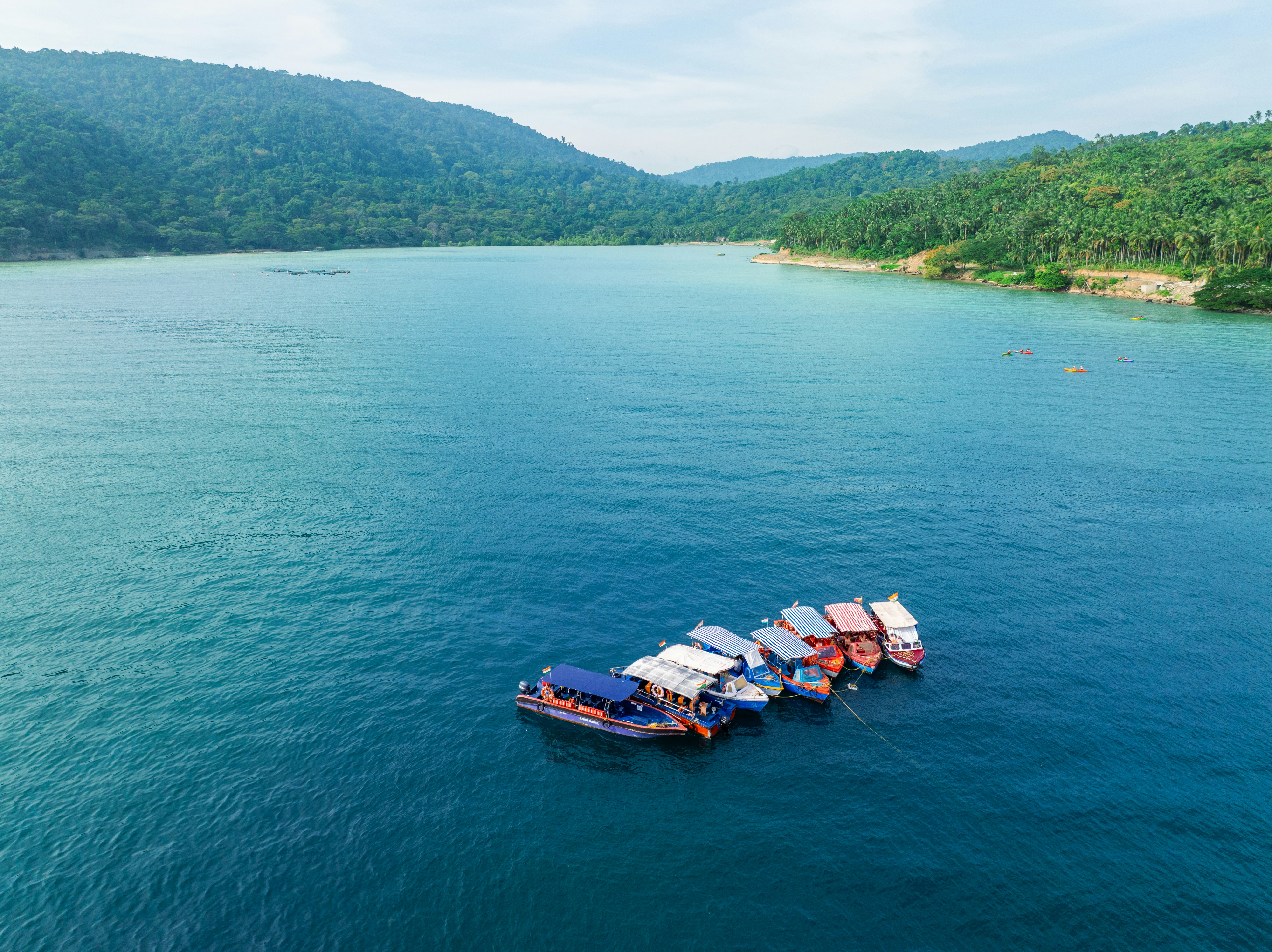 Tropical bay with anchored boats and lush green islands.