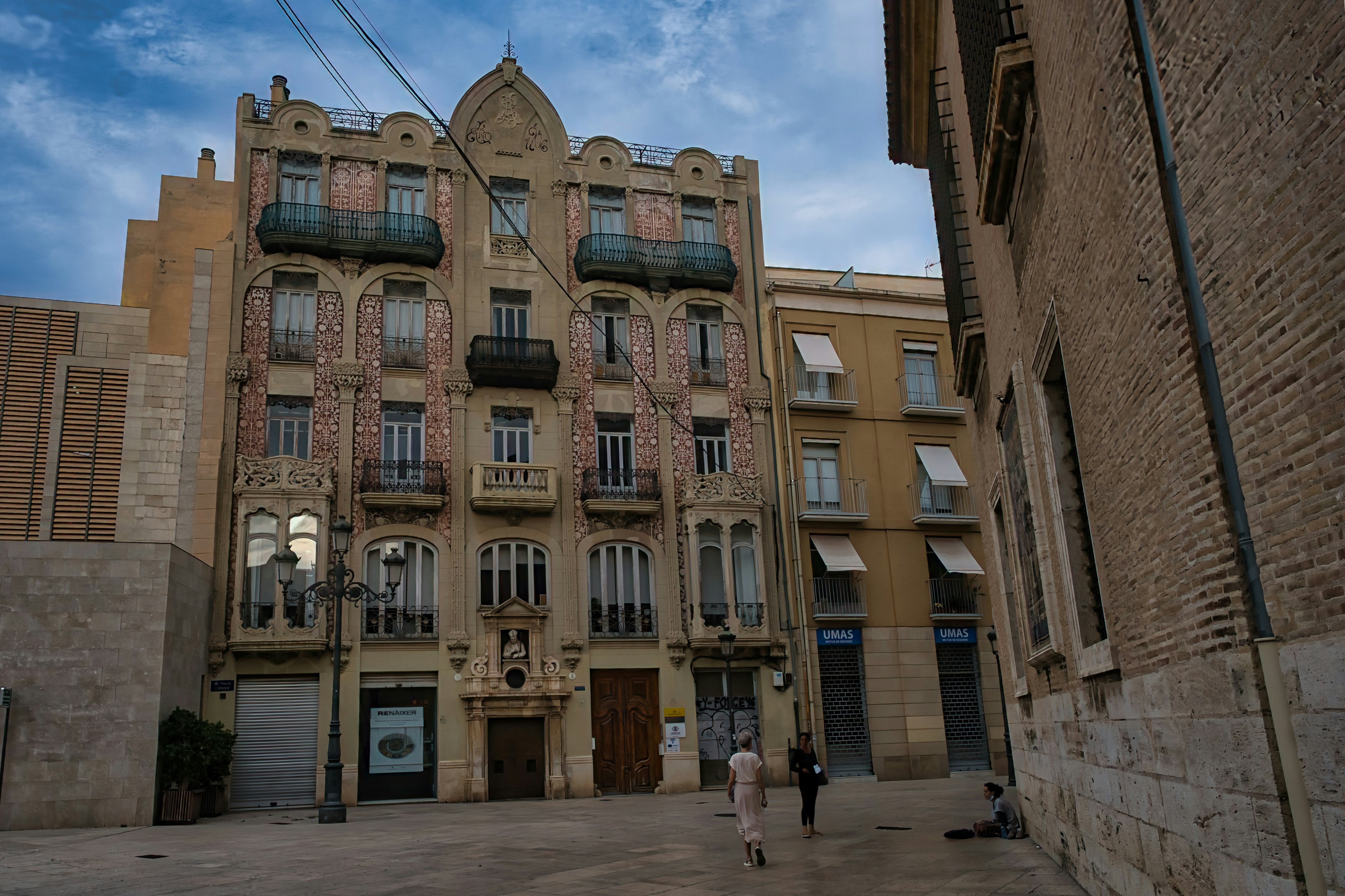 Ornate historic building with balconies in a european city plaza.