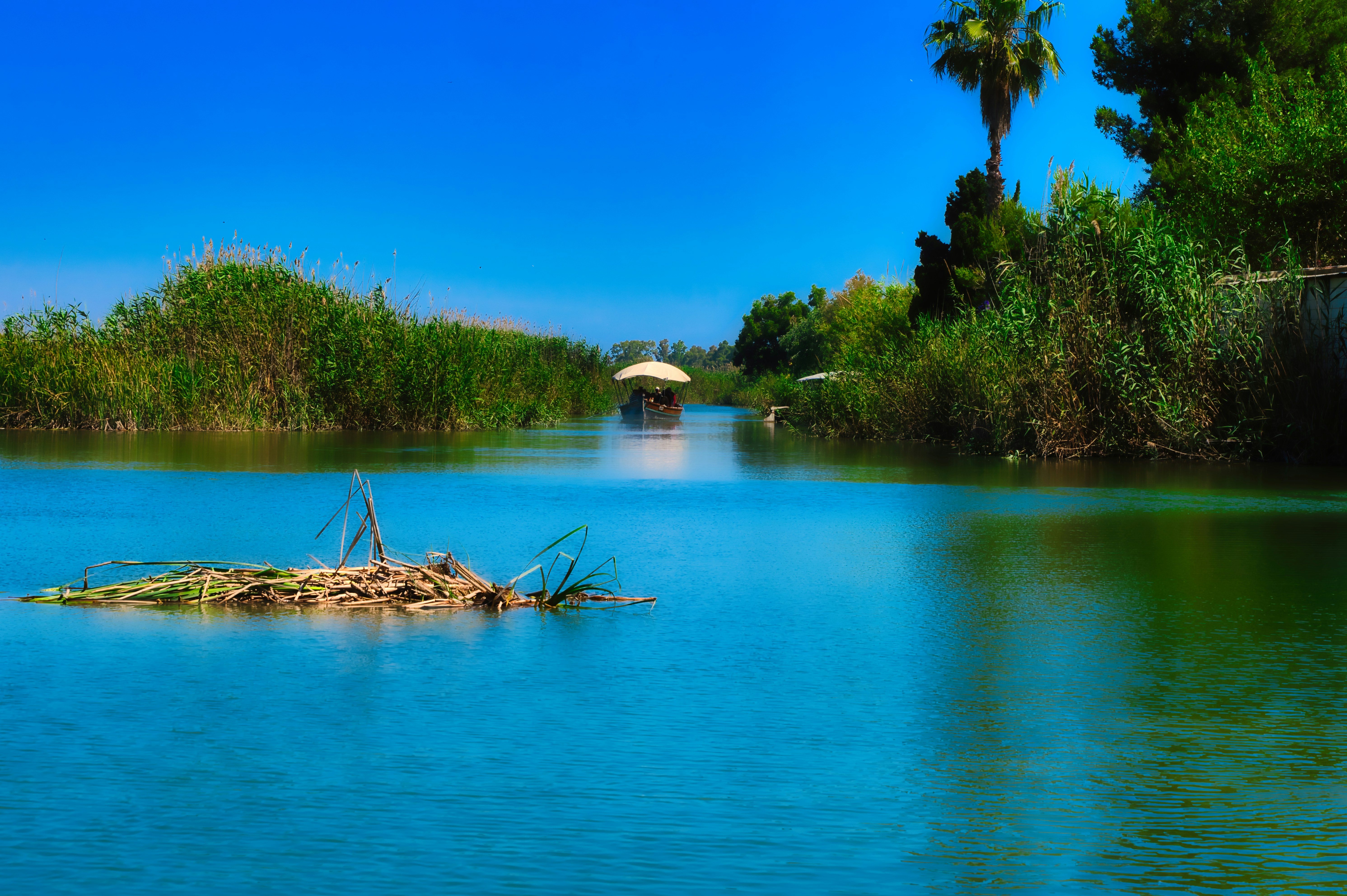 Floating refuge: a narrow island and umbrella on a tranquil blue river