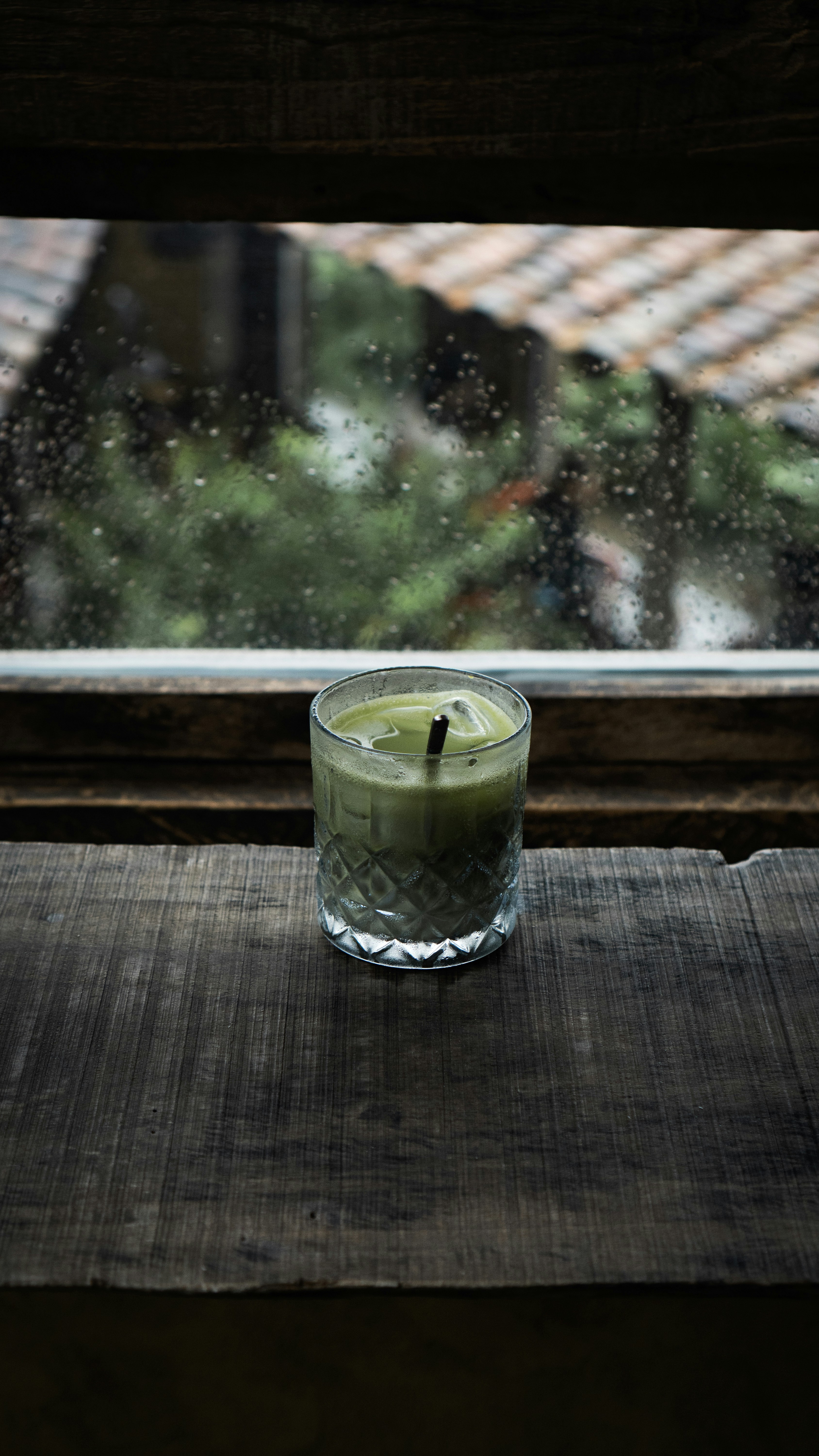 Green Cocktail on Weathered Wood by Rain-Dim Window