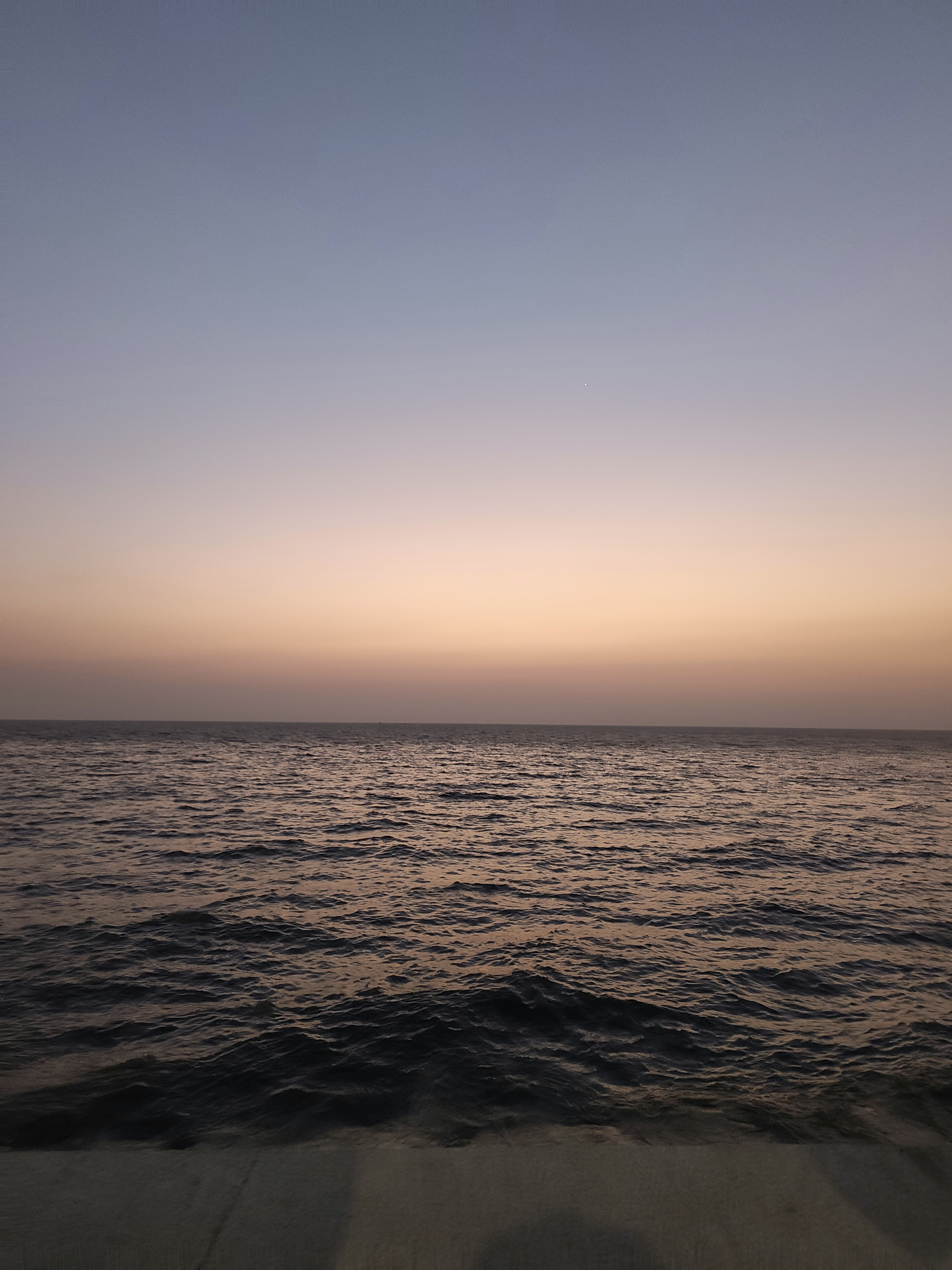 Calm ocean water under a beautiful gradient sunset sky.