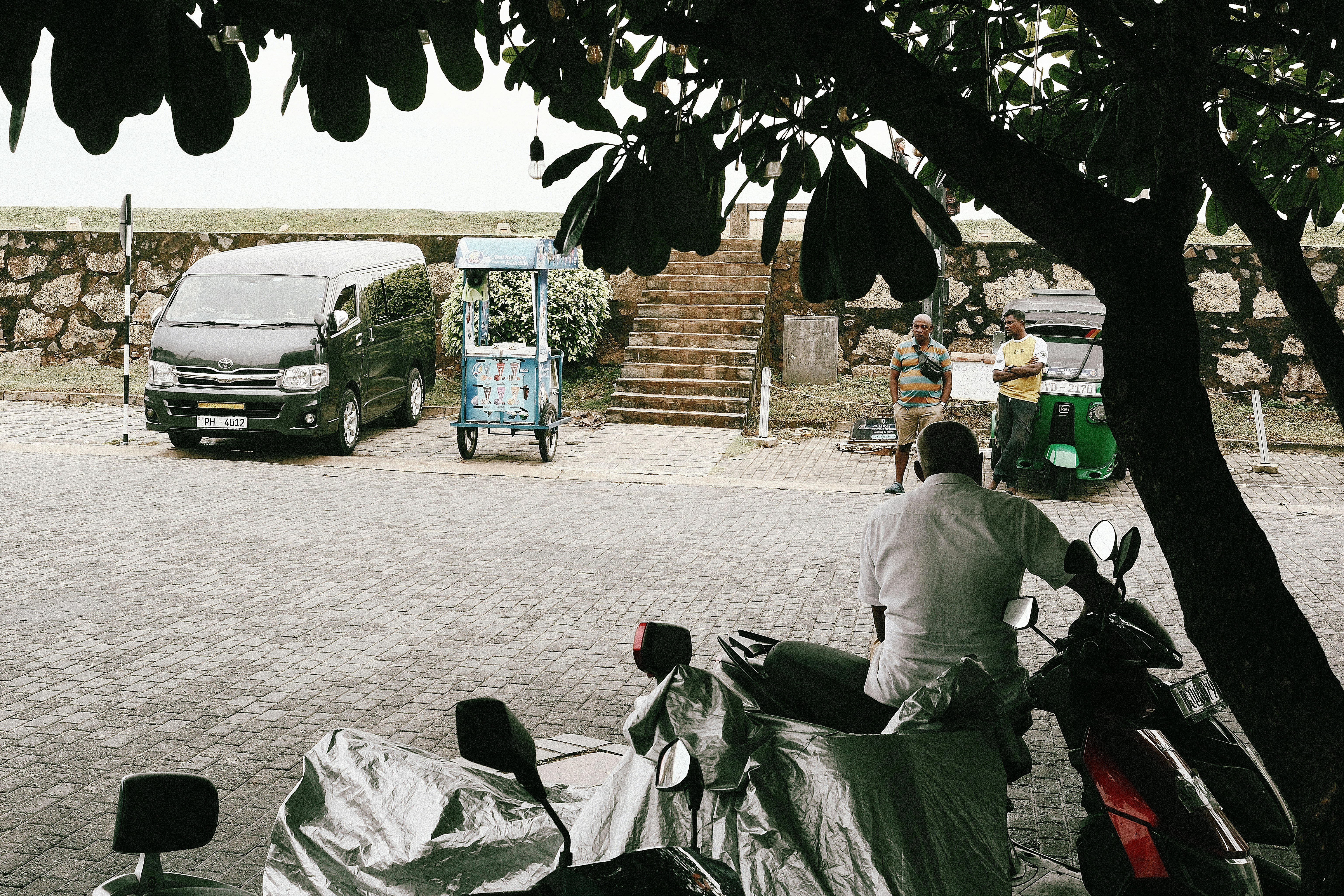 Hidden Motif Under the Shade: A Street Scene Framed by Motorbikes