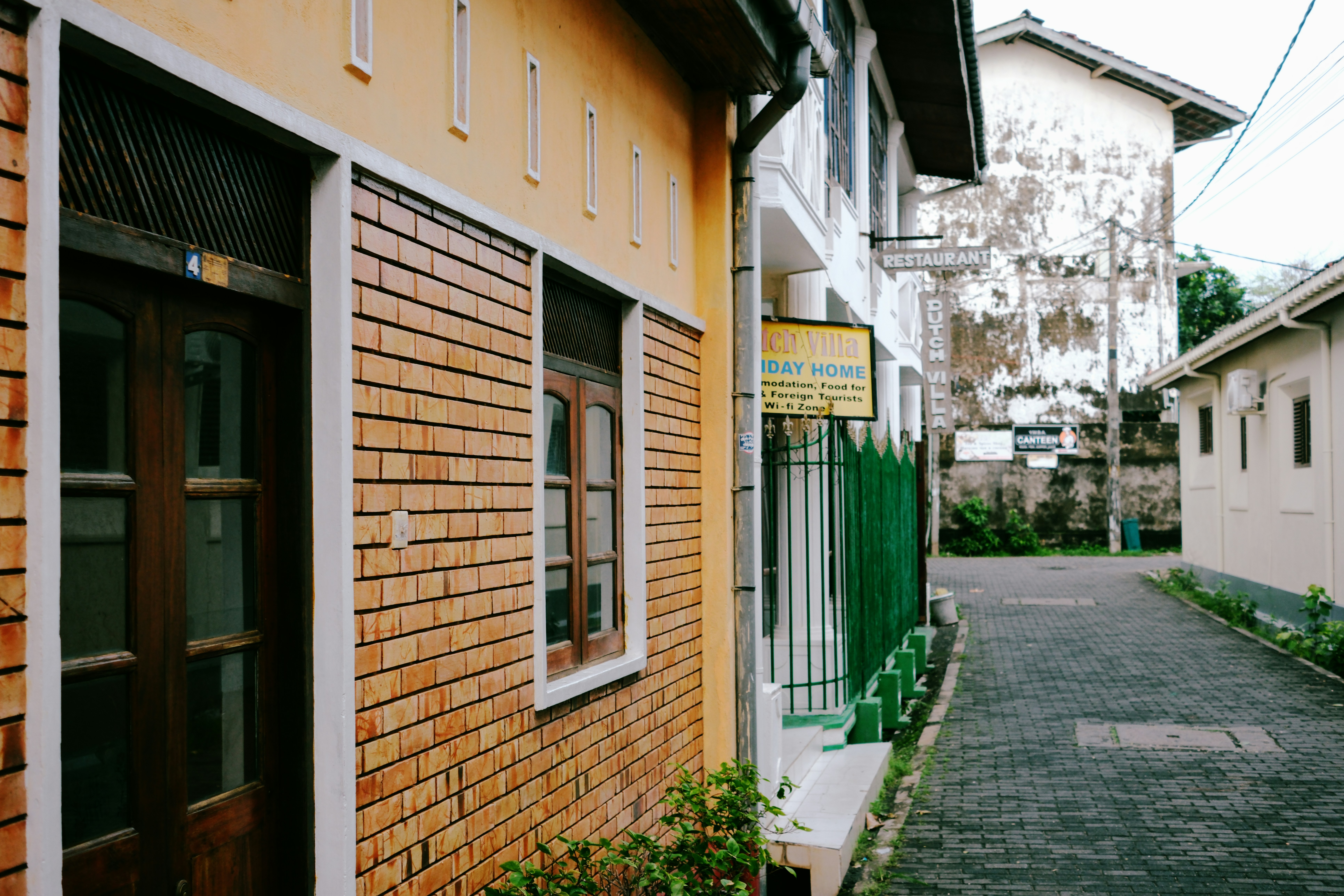Quiet Lane of Brick and White Facades
